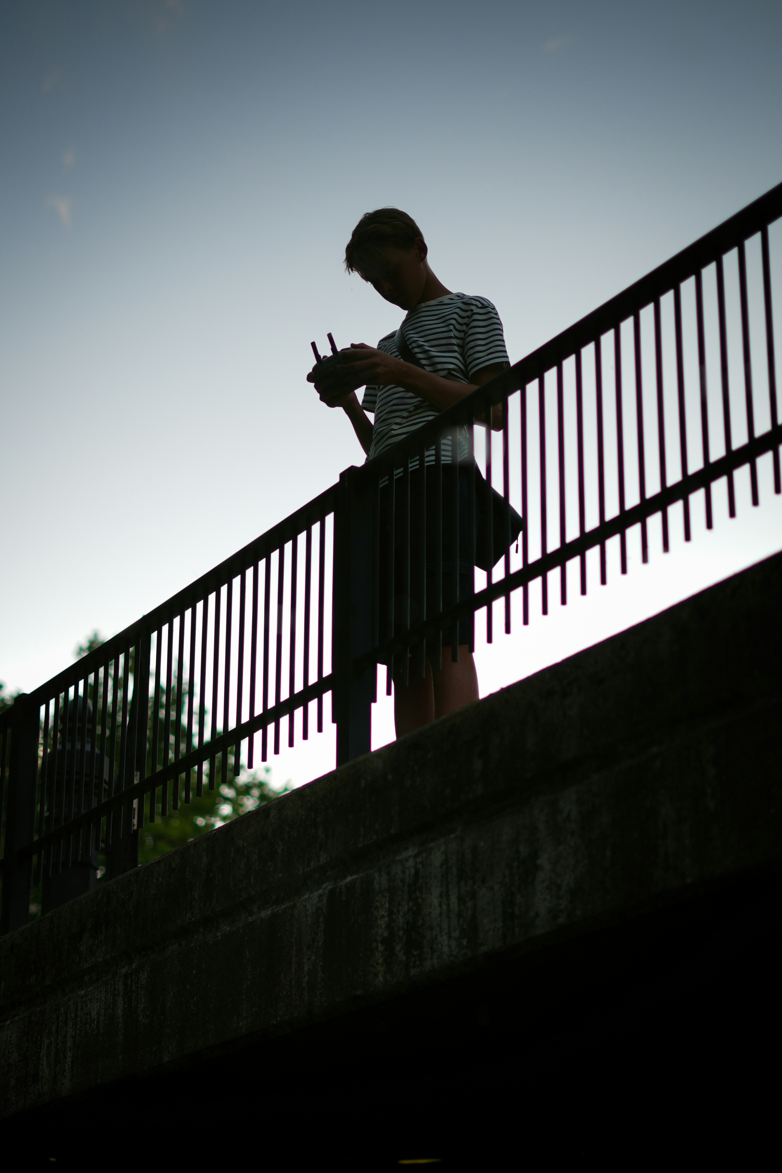 Silhouette on the Rail: A Quiet Moment Above Ground