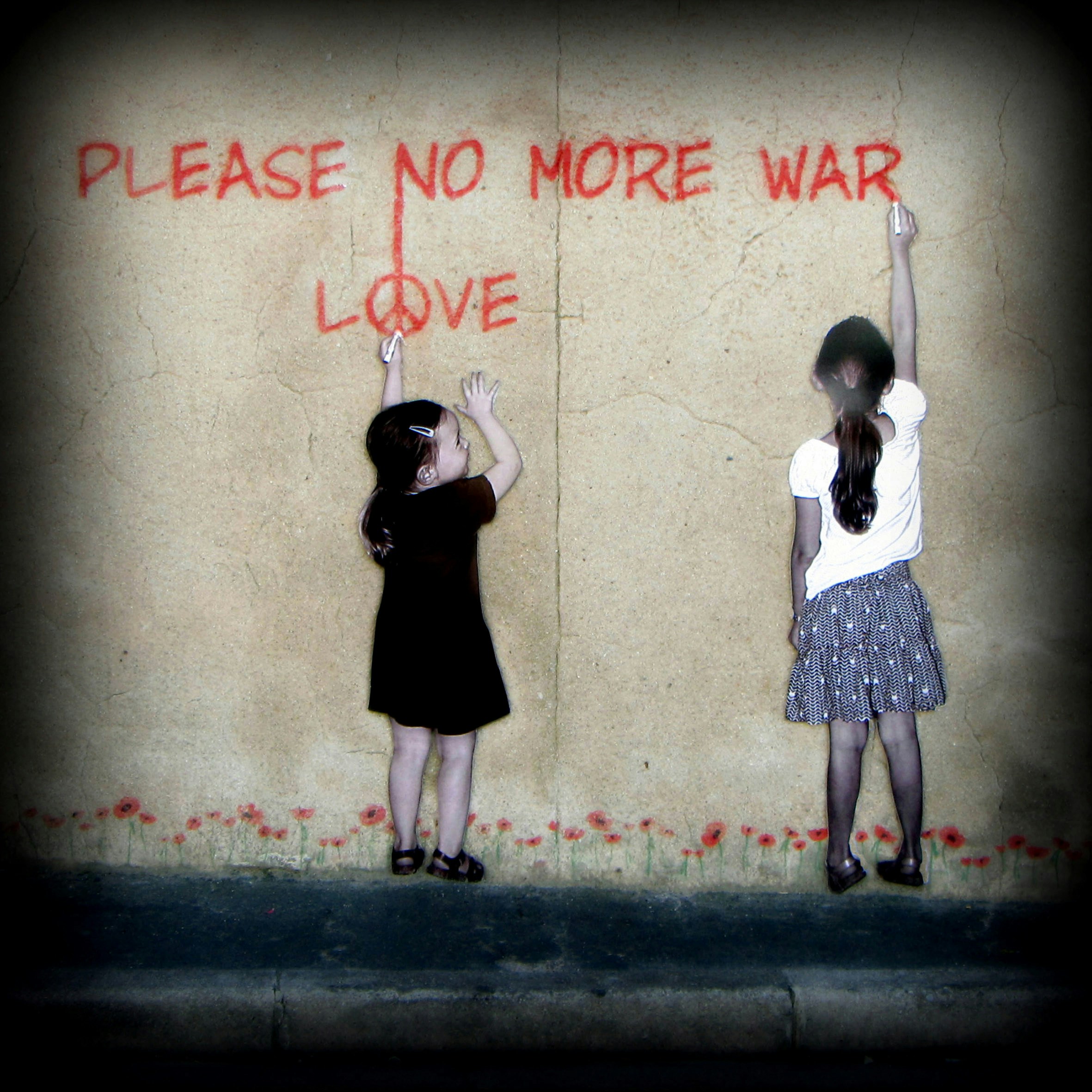 Two Girls Stand Against a Graffiti Wall with Raised Hands