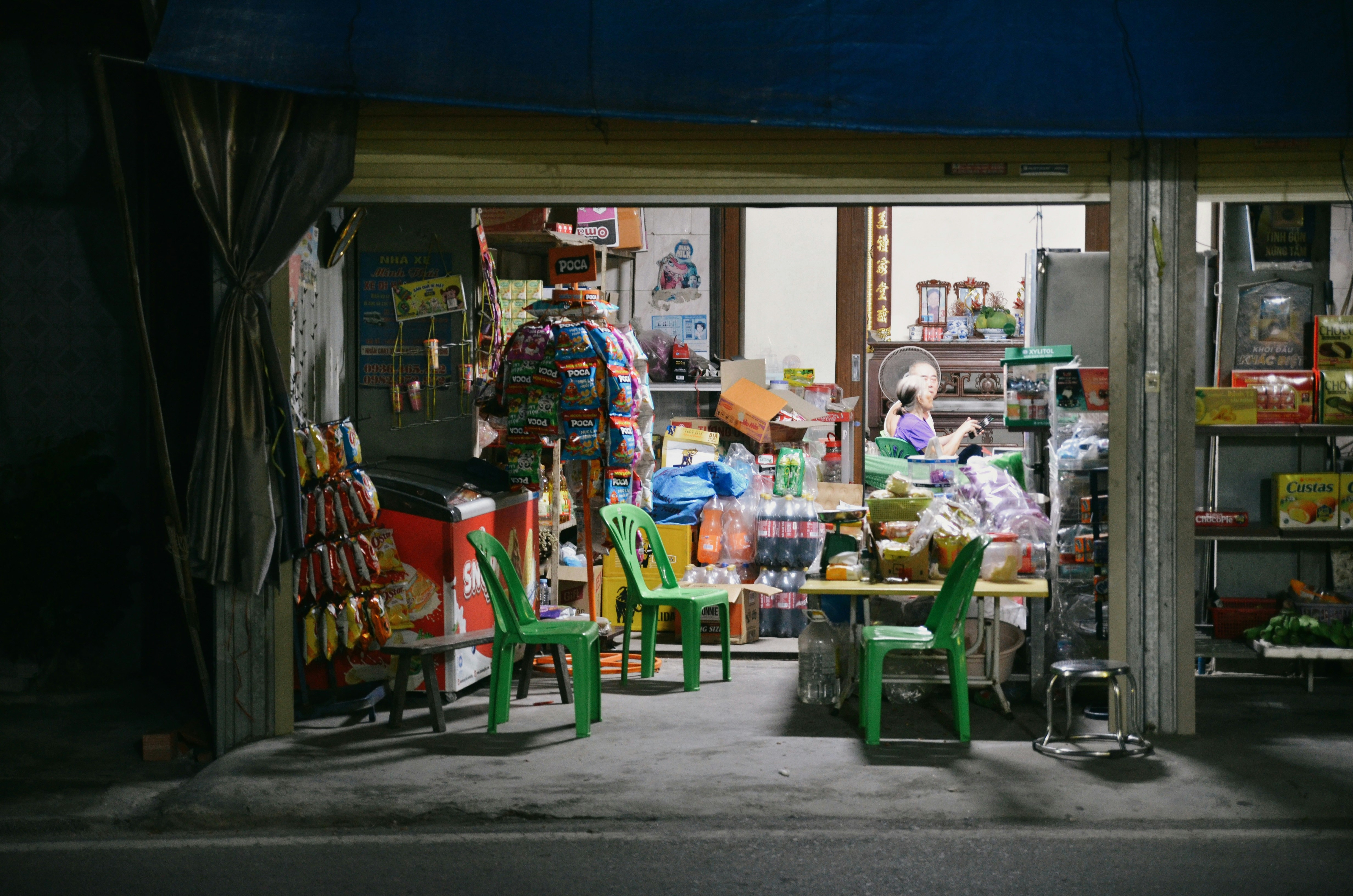Market Night: Neon Green Chairs and Quiet Activity in a Lively Shop