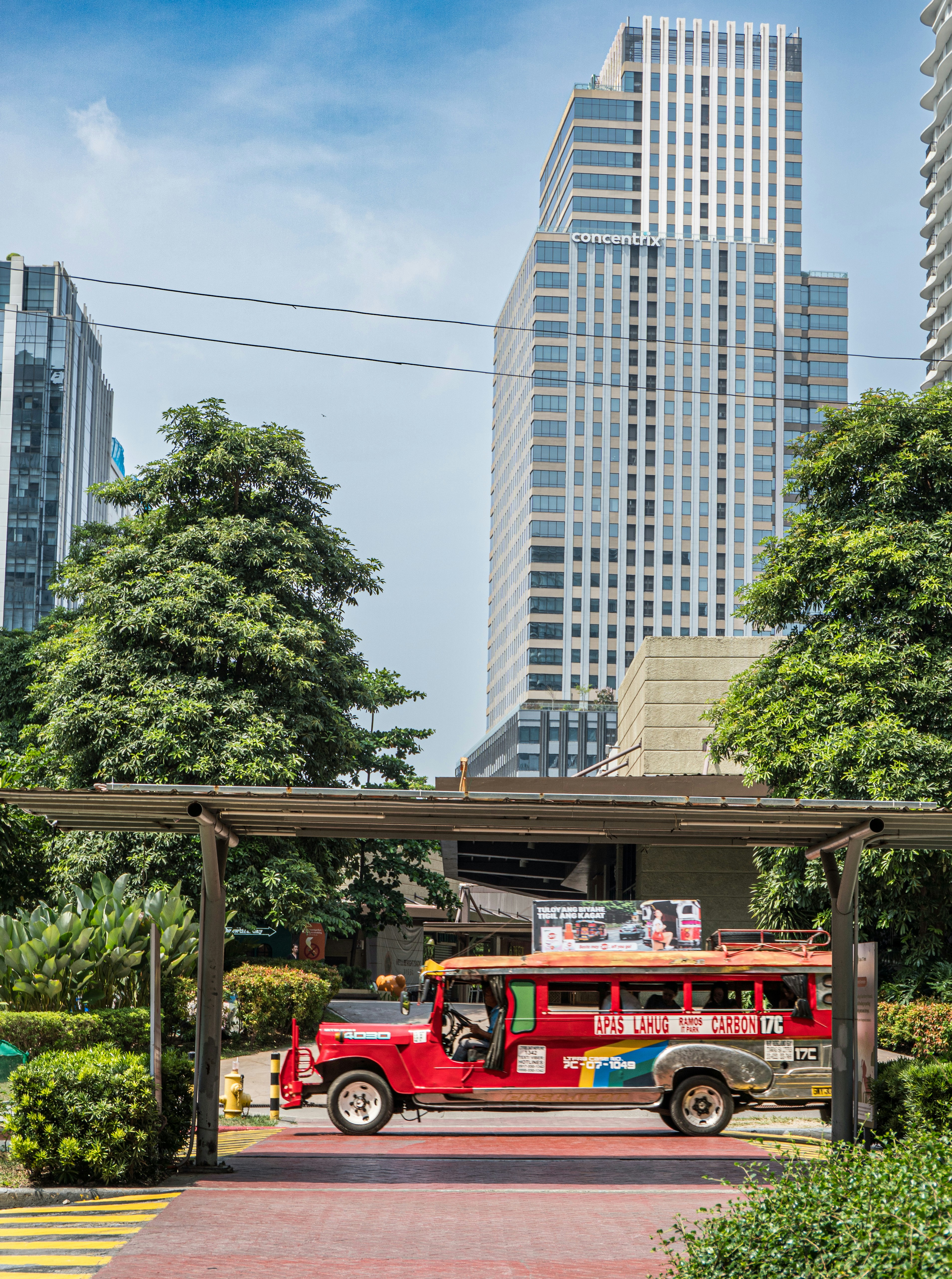 Urban Lime Boulevard: A Red Jeep Beneath the Skyscraper Canopy