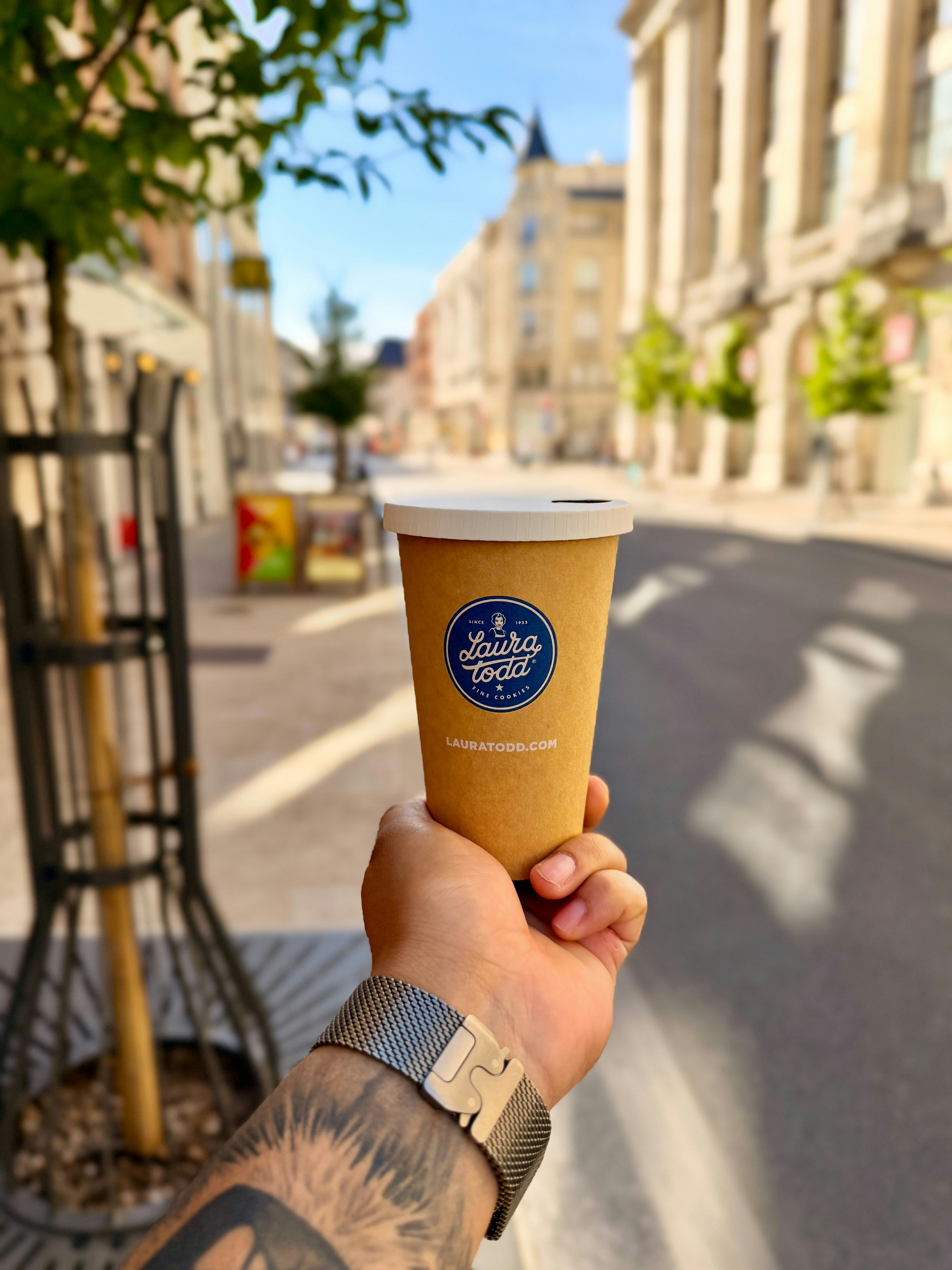 Cup of Dawn: Handheld Coffee Amid City Lines
