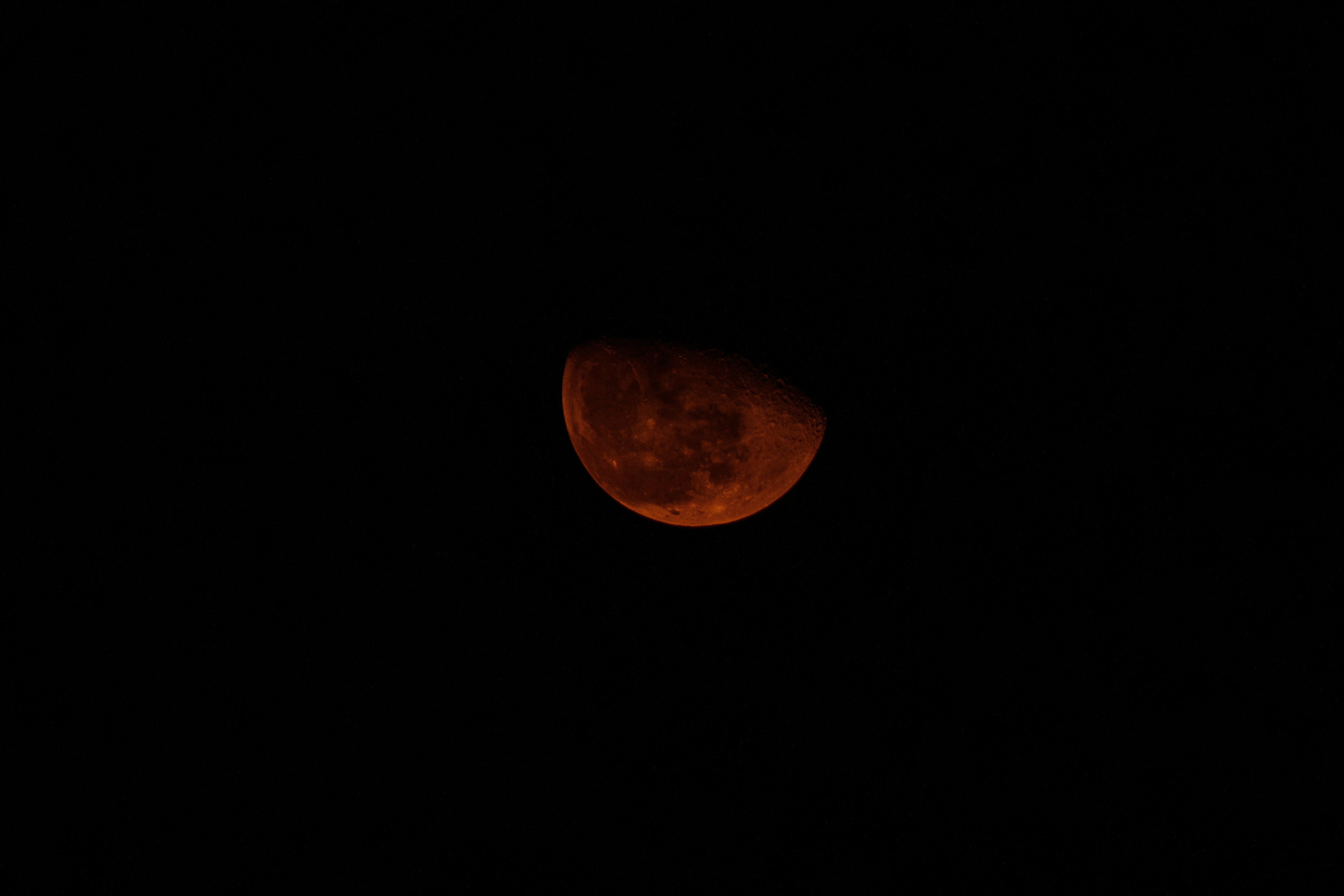 Crimson Crescent: A Quiet Lunar Eclipse Peers Through Darkness