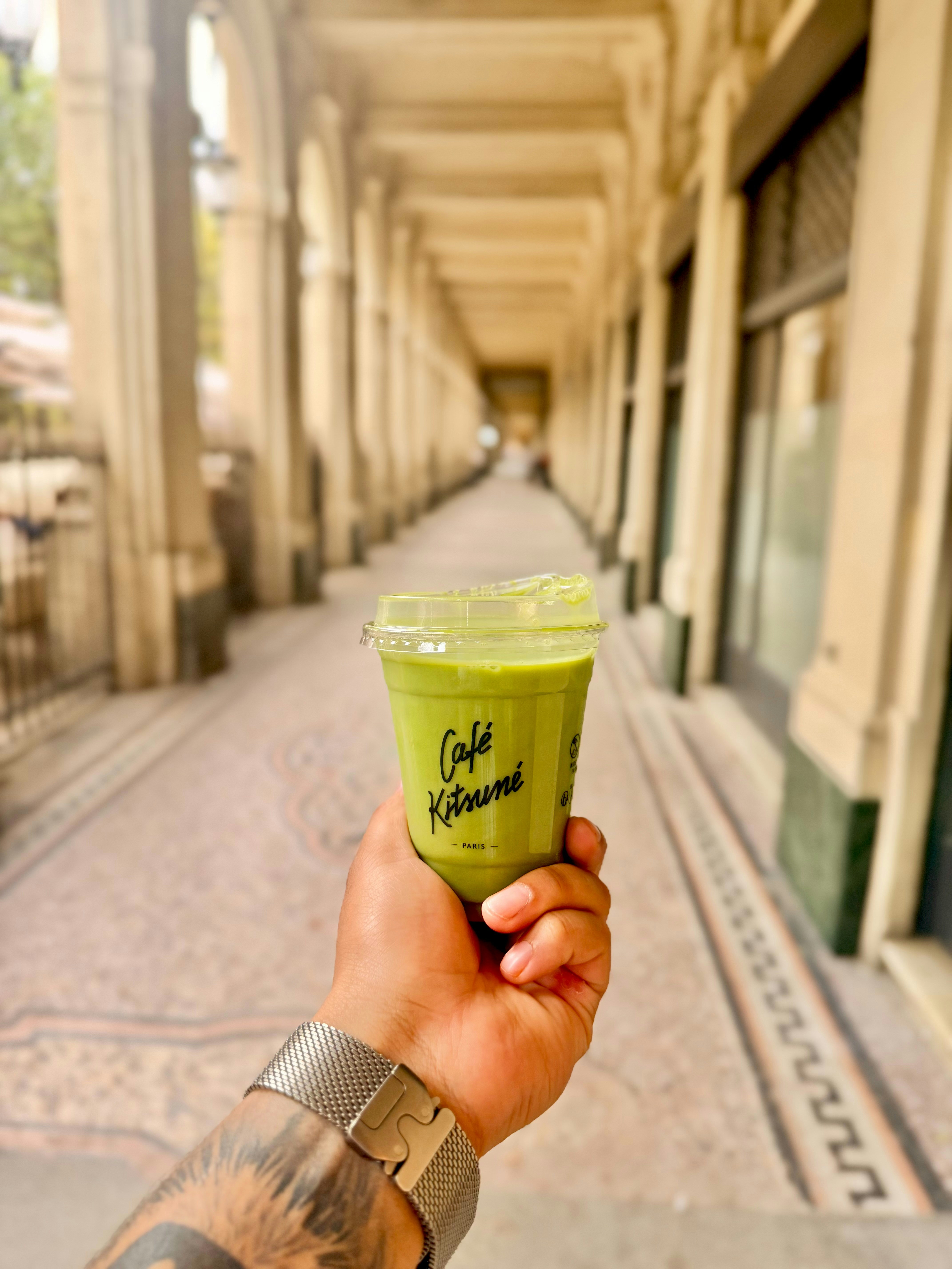 Green Smoothie in Hand, Alleyway Café Corridor