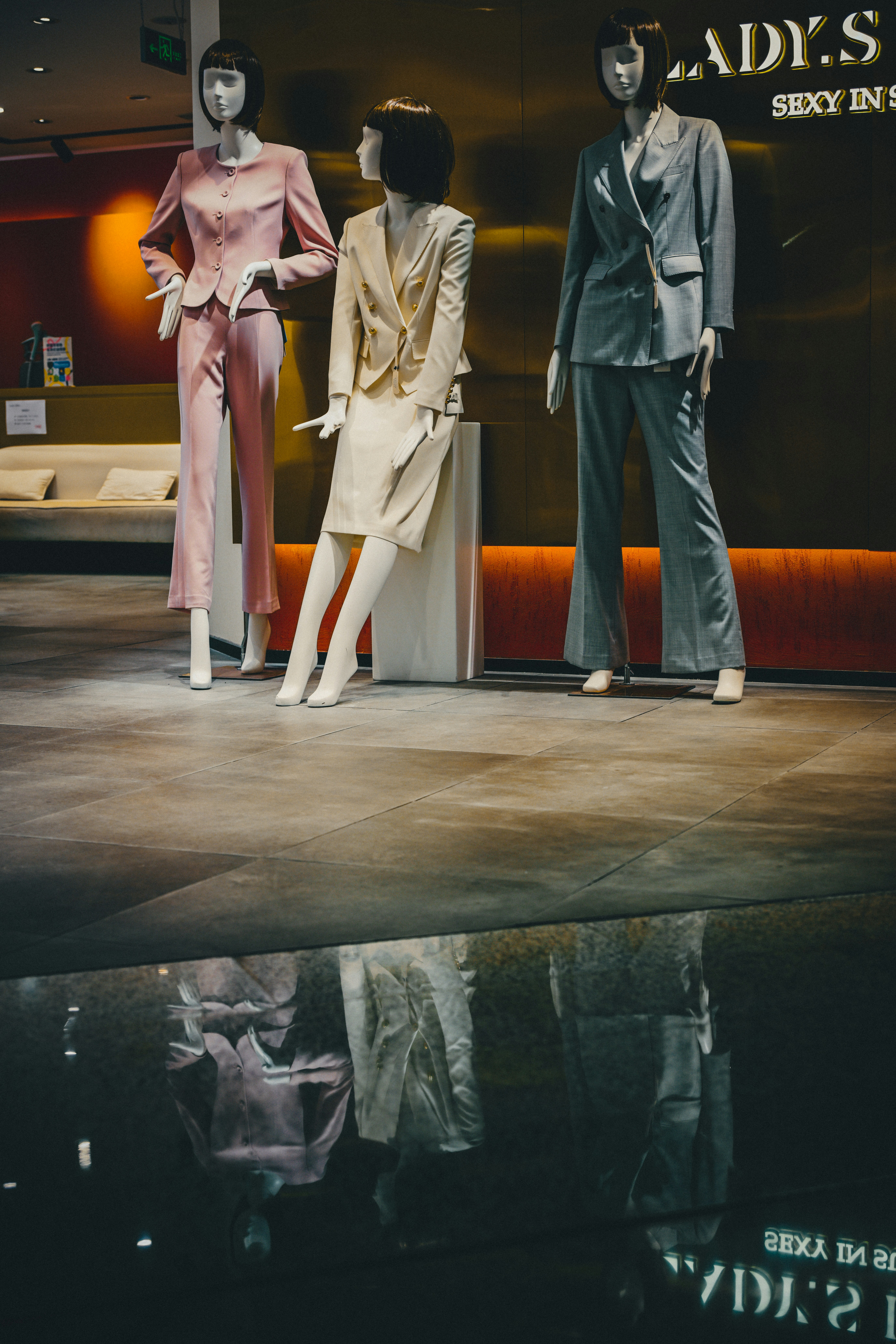 Mannequin Quartet: Velvet Suits and Neon Glow in a Shopfront Display