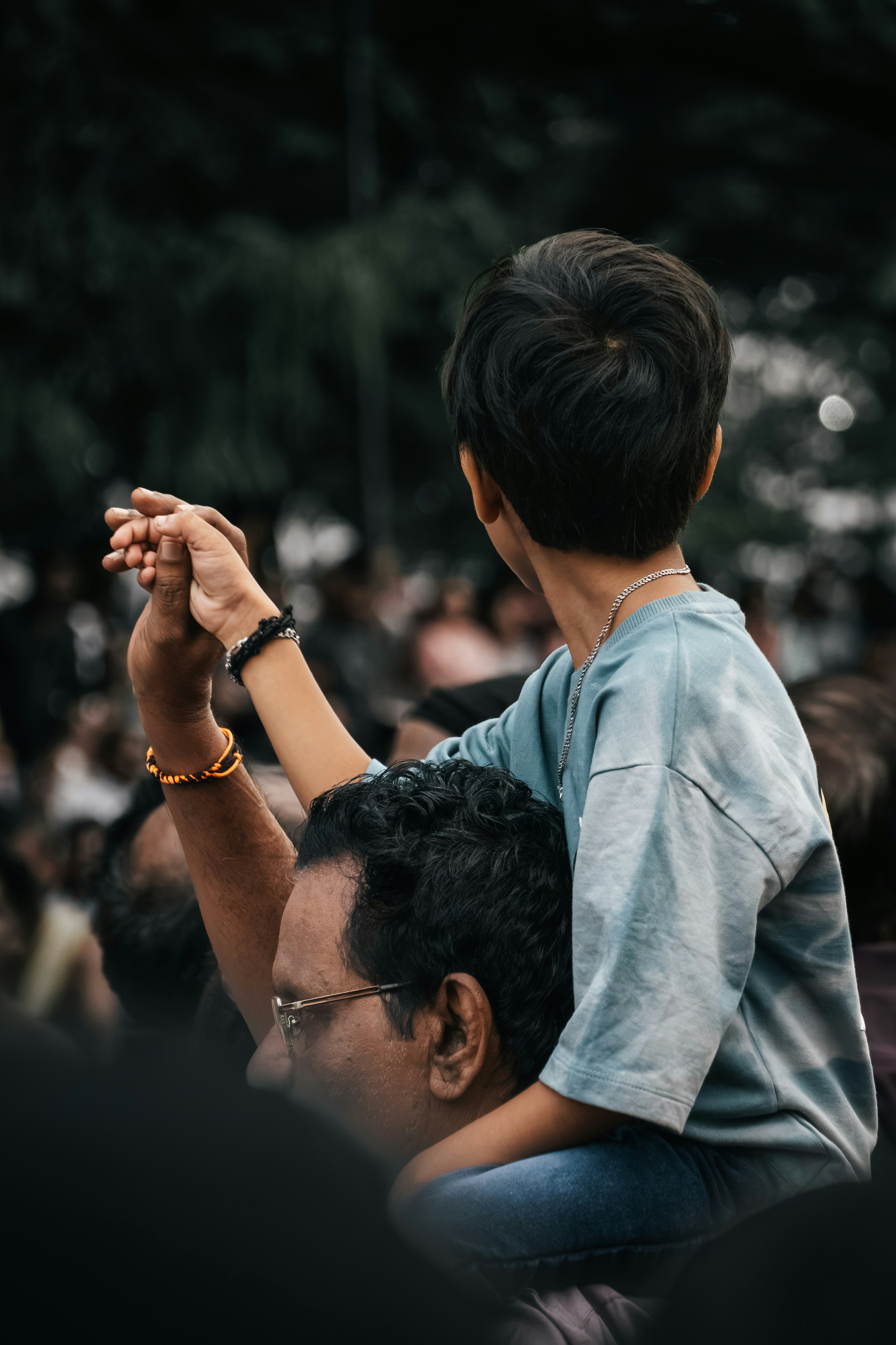 Parent and Child on Shoulders: A Shared Moment in the Crowd