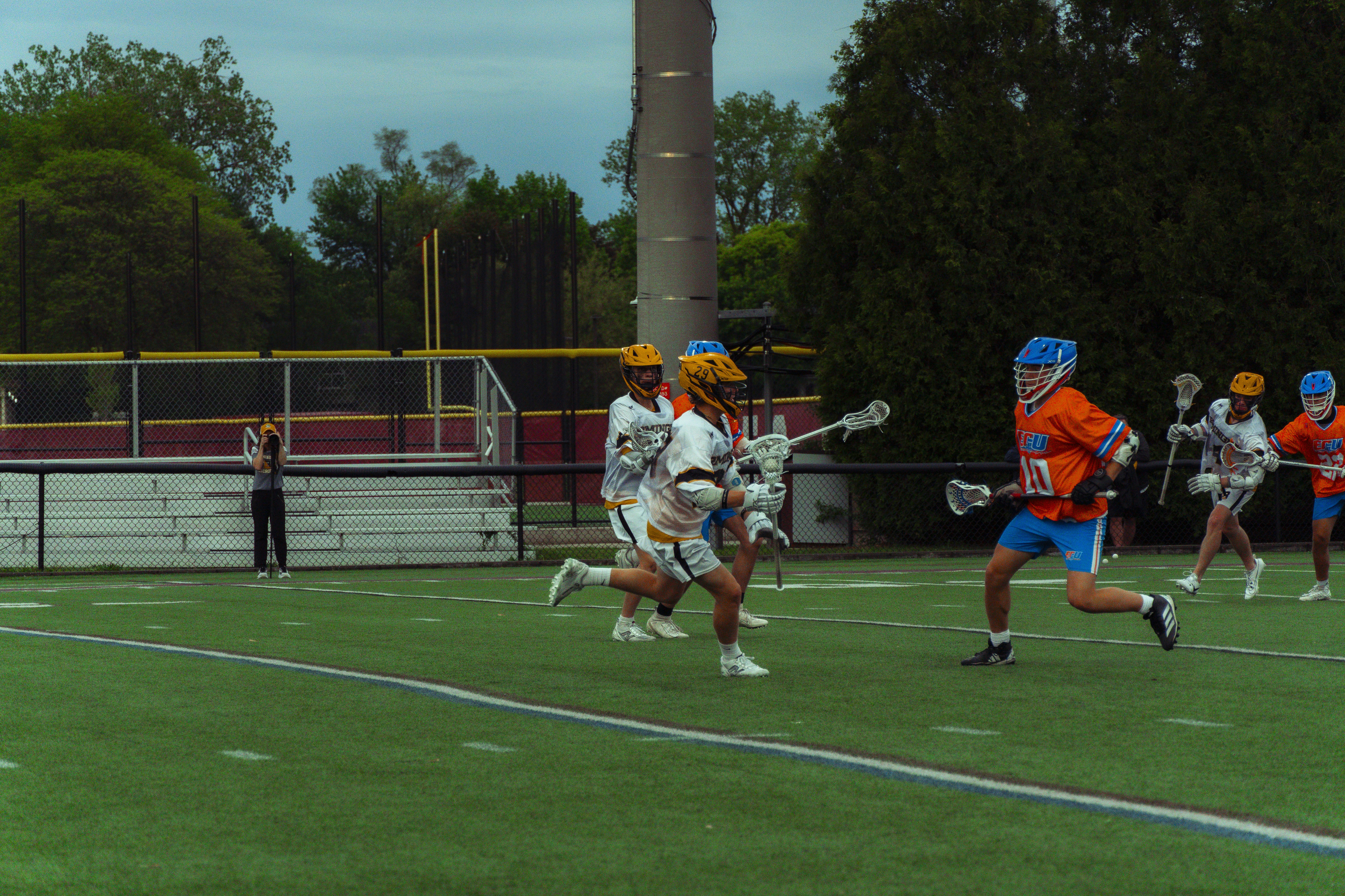 Midfield Charge: A Lacrosse Confrontation Under Sunday Lights