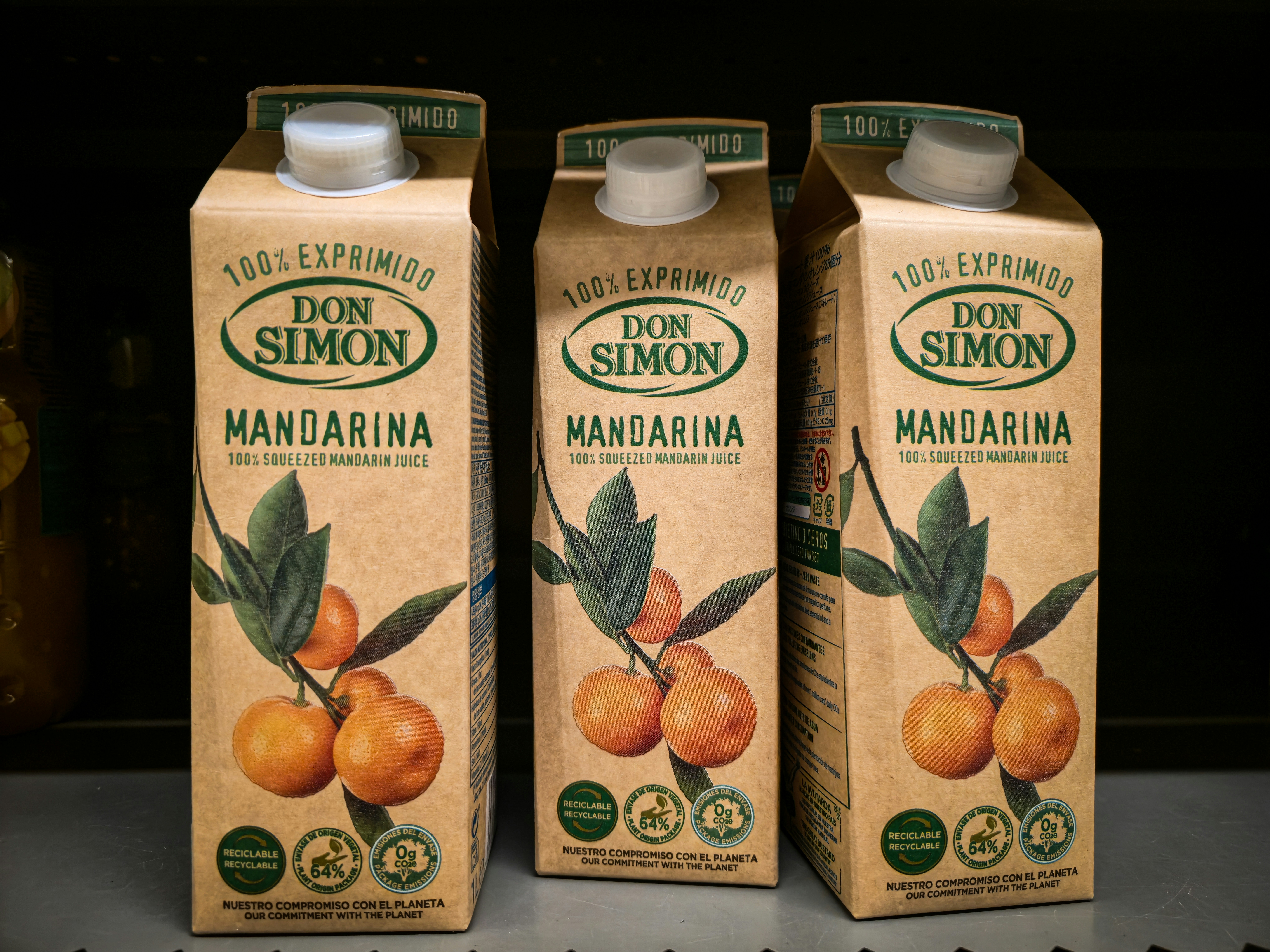 Three Tetra-Pack Oranges: A Row of Mandarina Juice on Display
