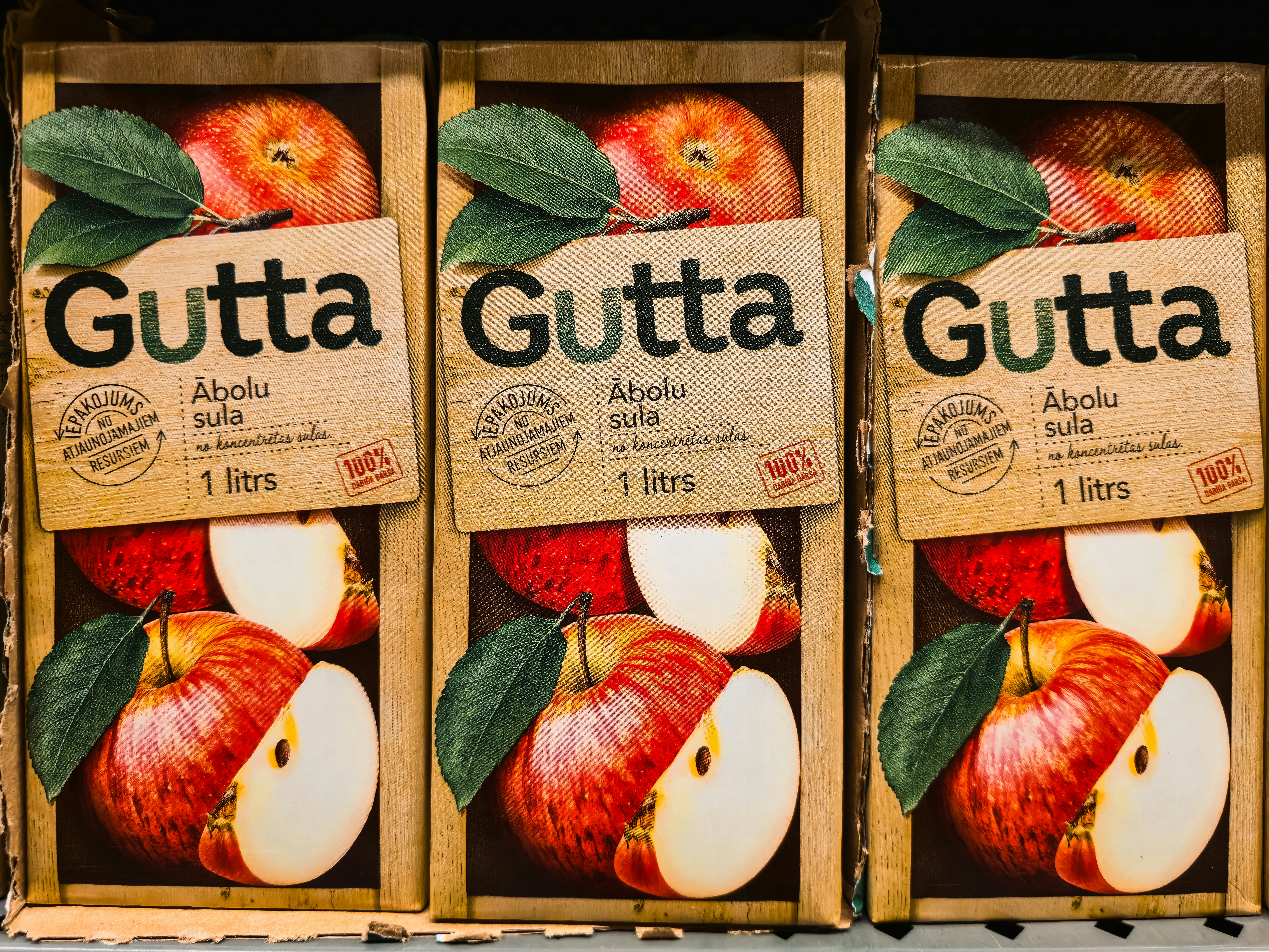 Gutta Apple juice cartons displayed on a supermarket shelf in Latvia.