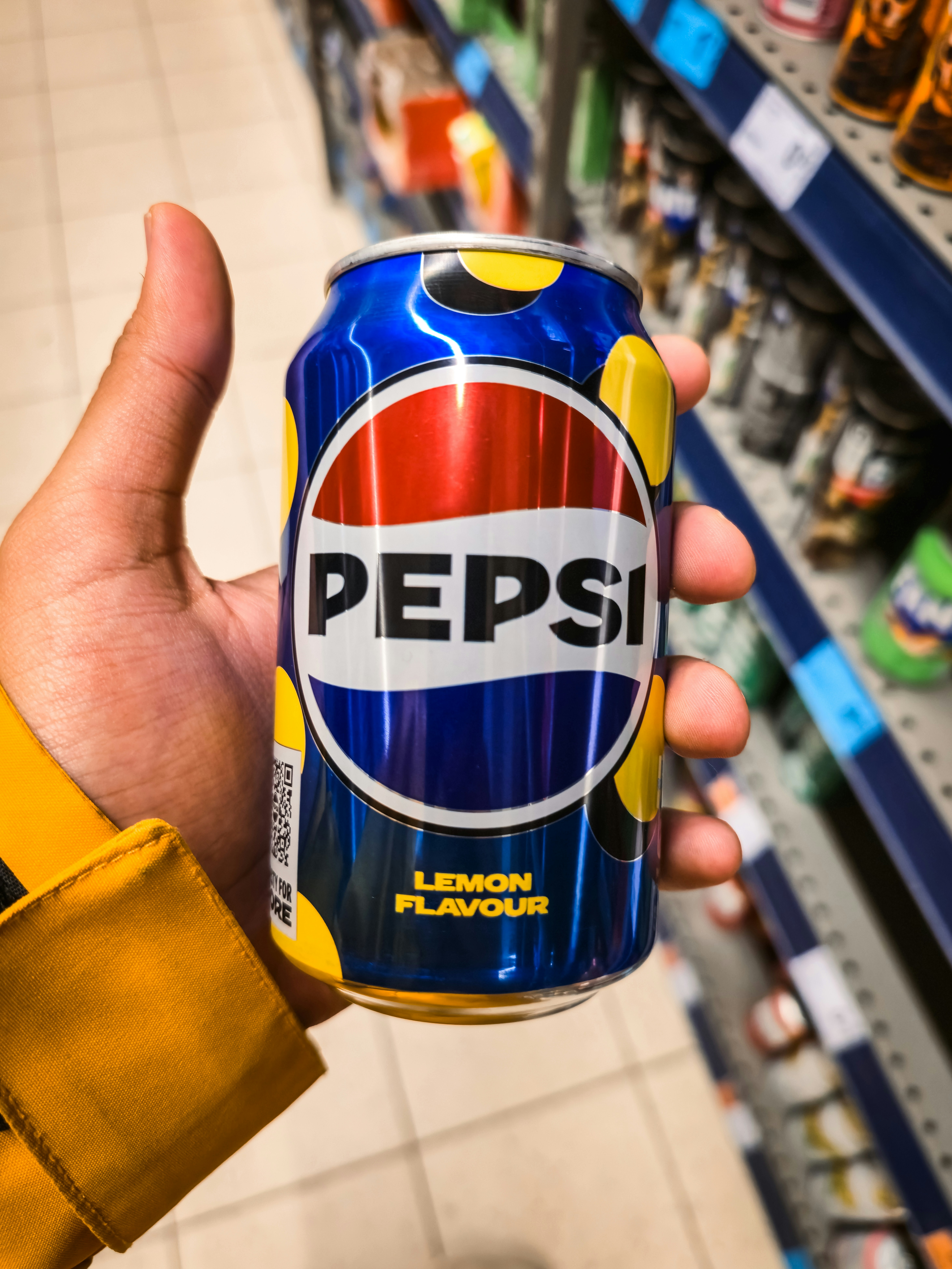 Lively can of Lemon Pepsi gripped in a shopper’s hand