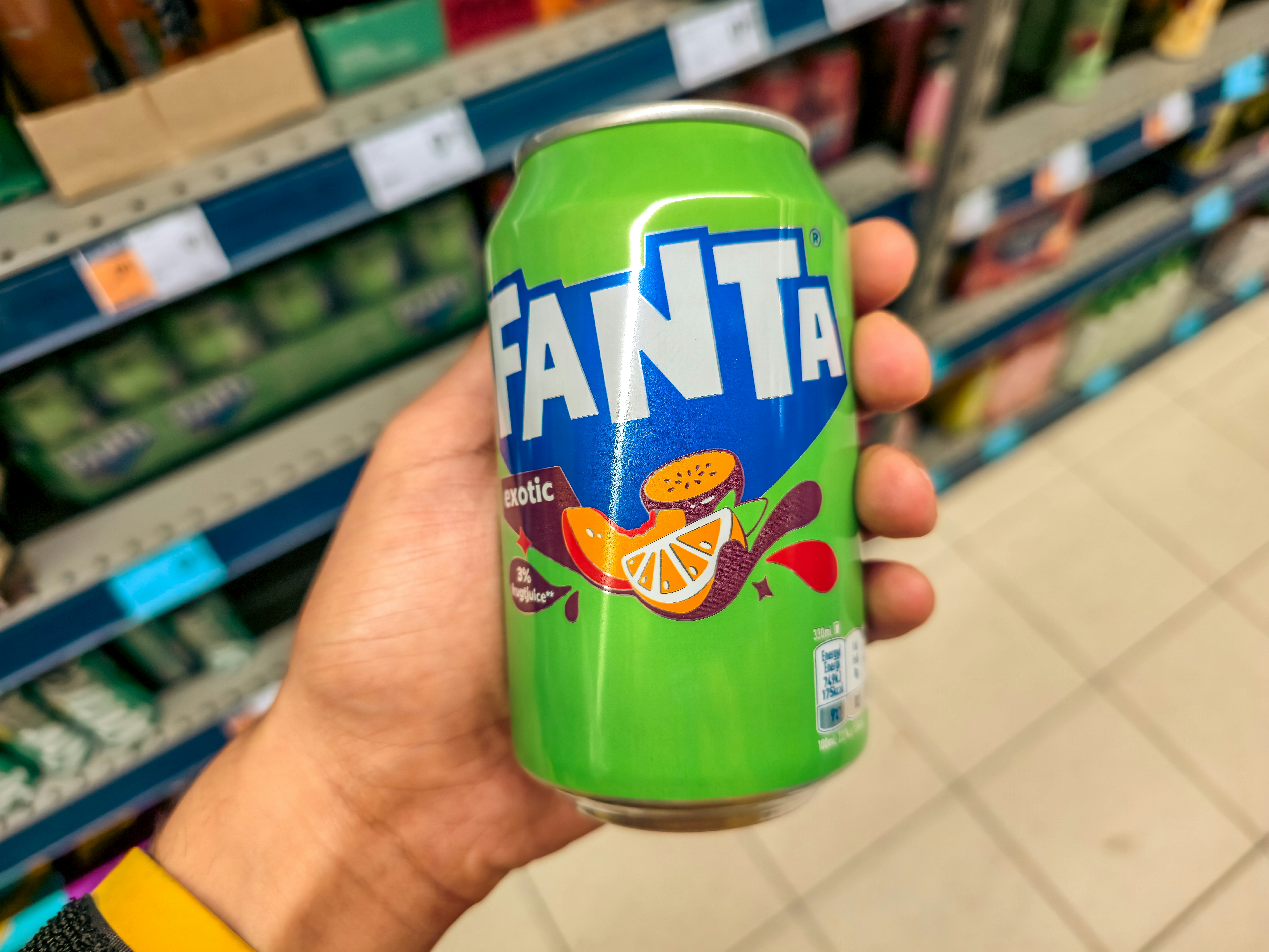 Green Fanta in Focus: A Handheld Soda Moment at Aisle Level