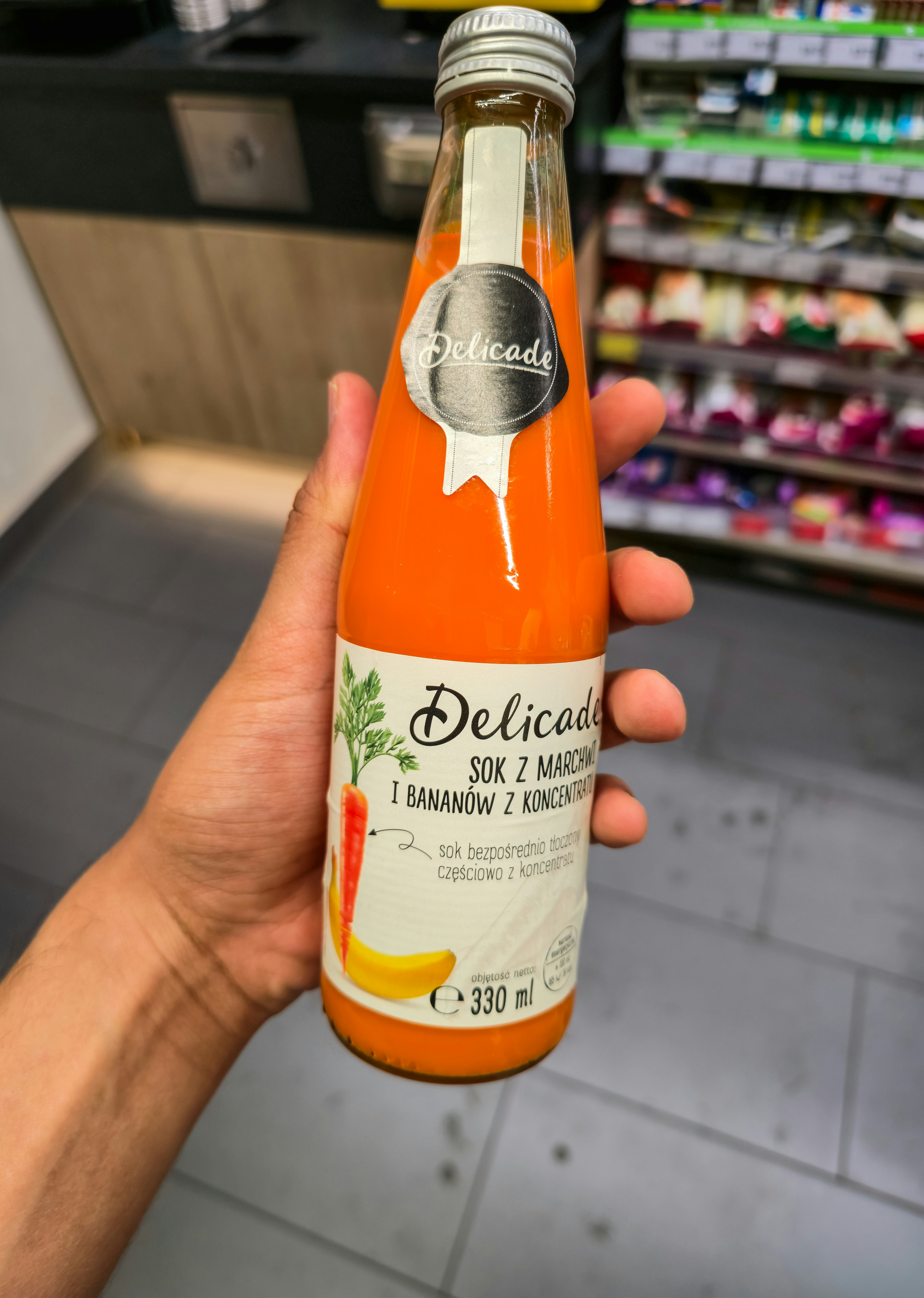 Vivid Orange Elixir: Handheld Bottle Crowned by a Store Aisle