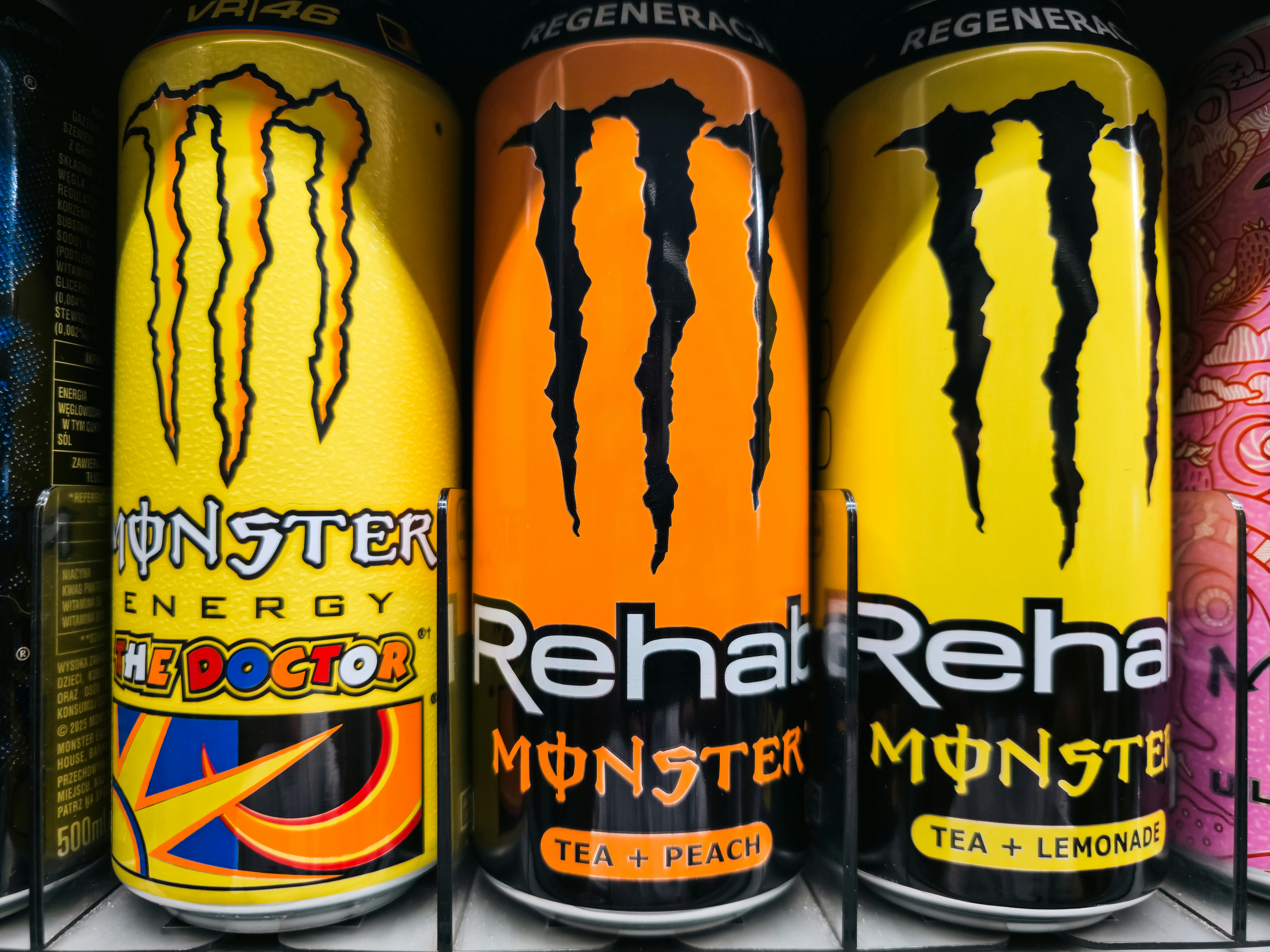 Monstrous Energy Trio: A Row of Monster Cans in a Convenience Aisle