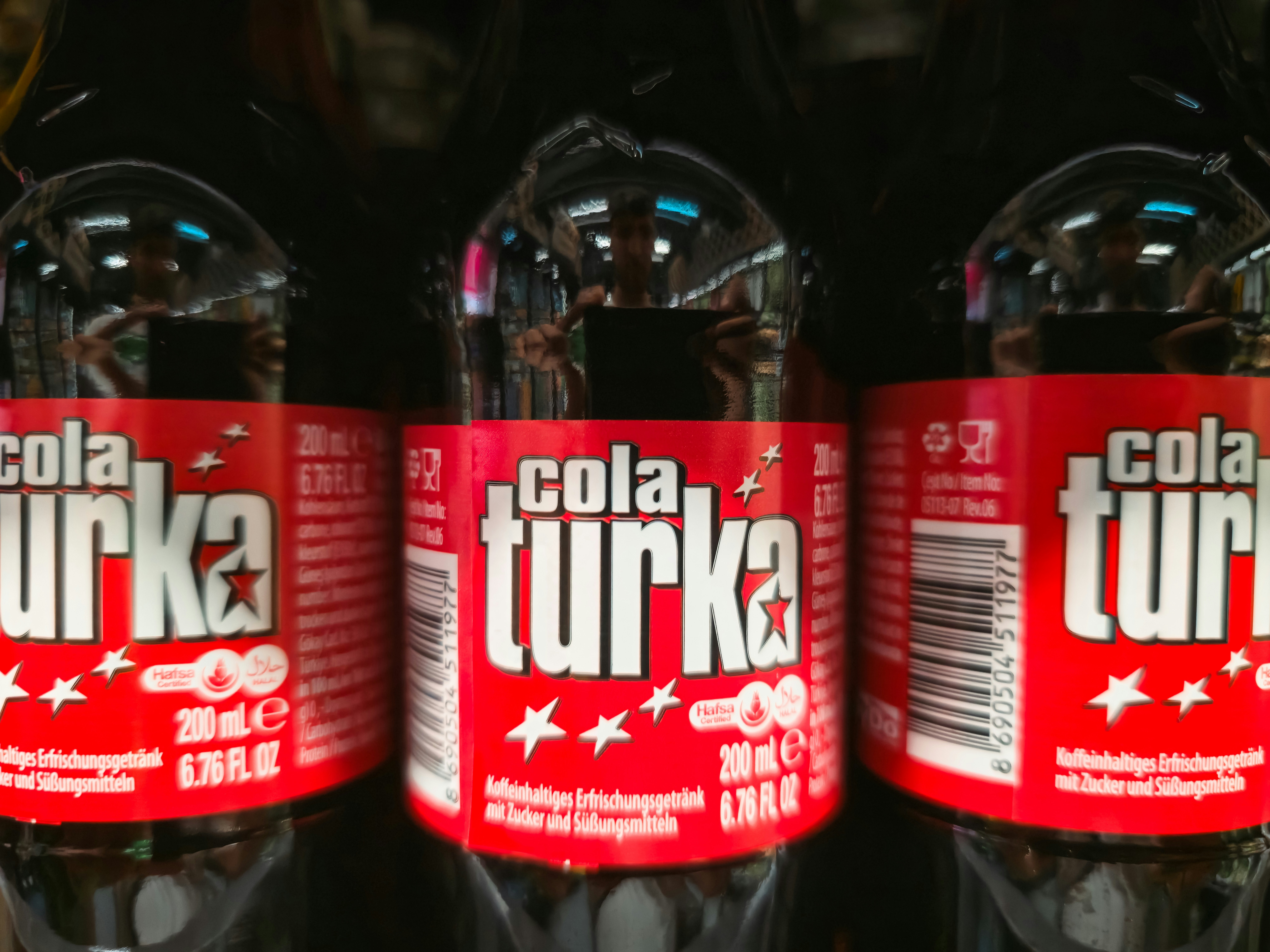 Three Bottles of Cola Turka: Red Labels, Reflections, and Repetition