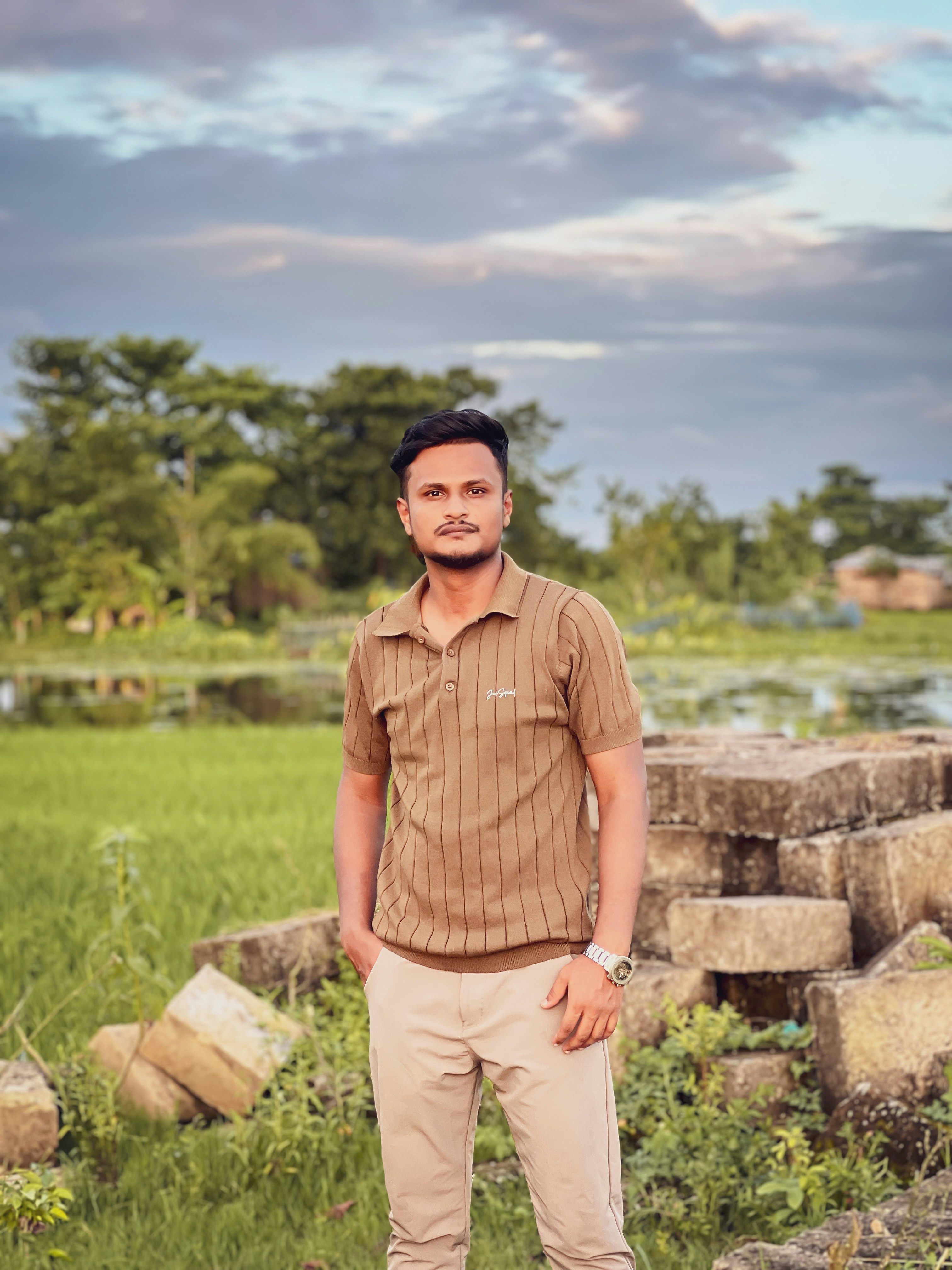 Portrait at the Riverbed: A Quiet Stance Amidst Verdant Remnants