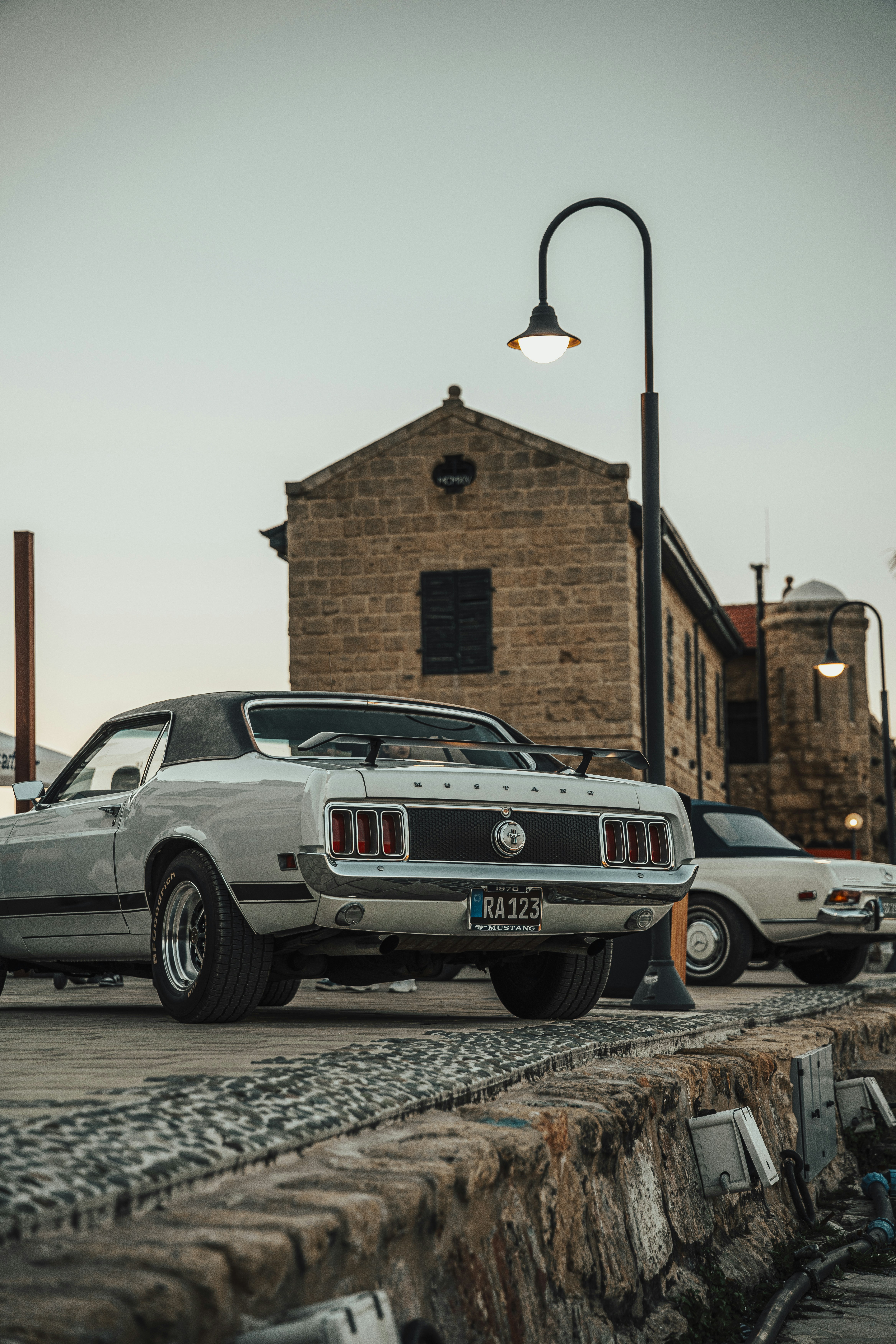  twilight at the harbor: a chrome muscle car by the stone quay