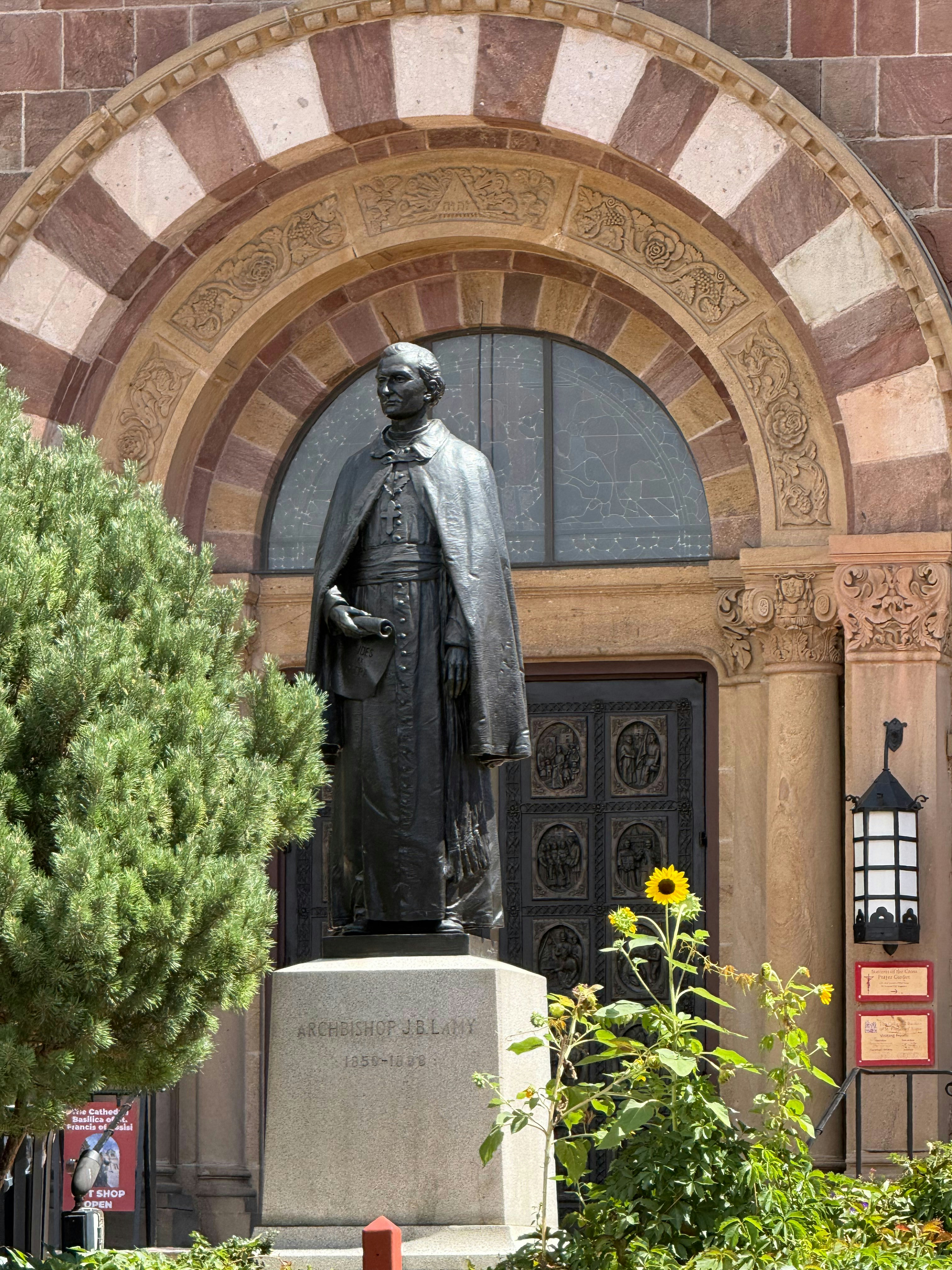 Statue in Front of Romanesque Gateway with Sunflowers
