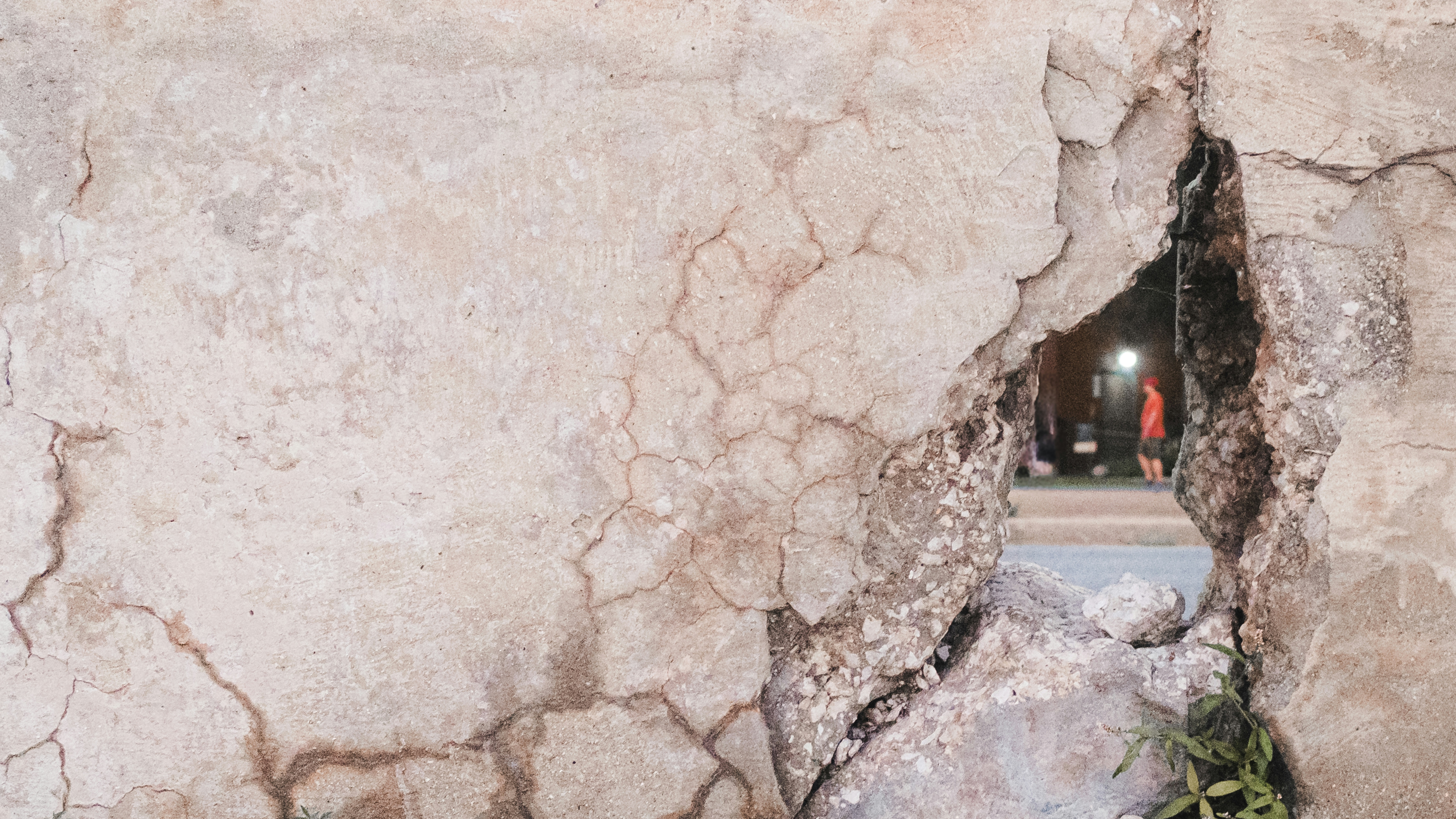 Cracked Wall, Hidden Streetlight: A Quiet Moment Beyond the Gap