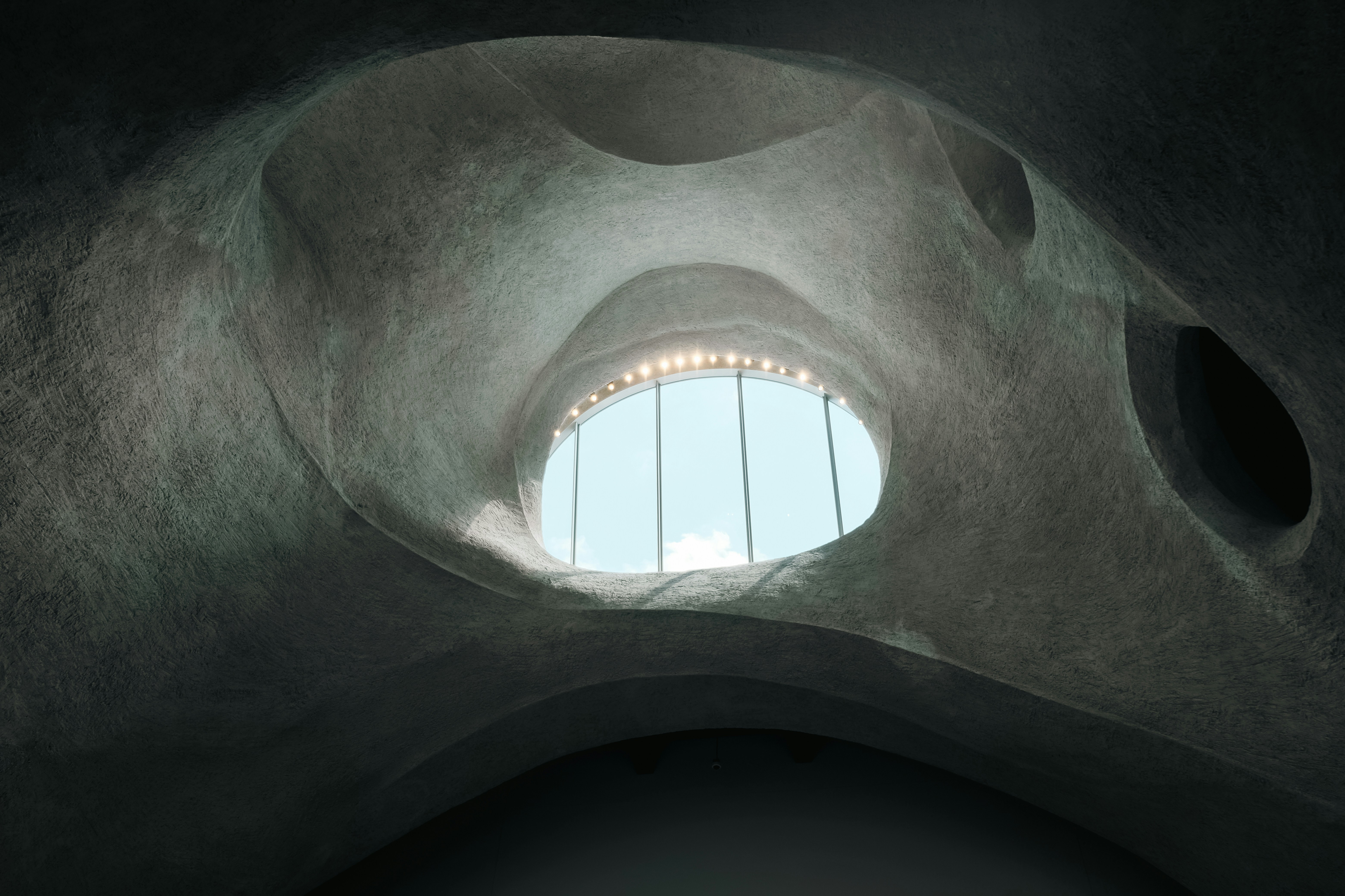 Cavernous skylight: a sculpted opening spilling daylight into a curved interior