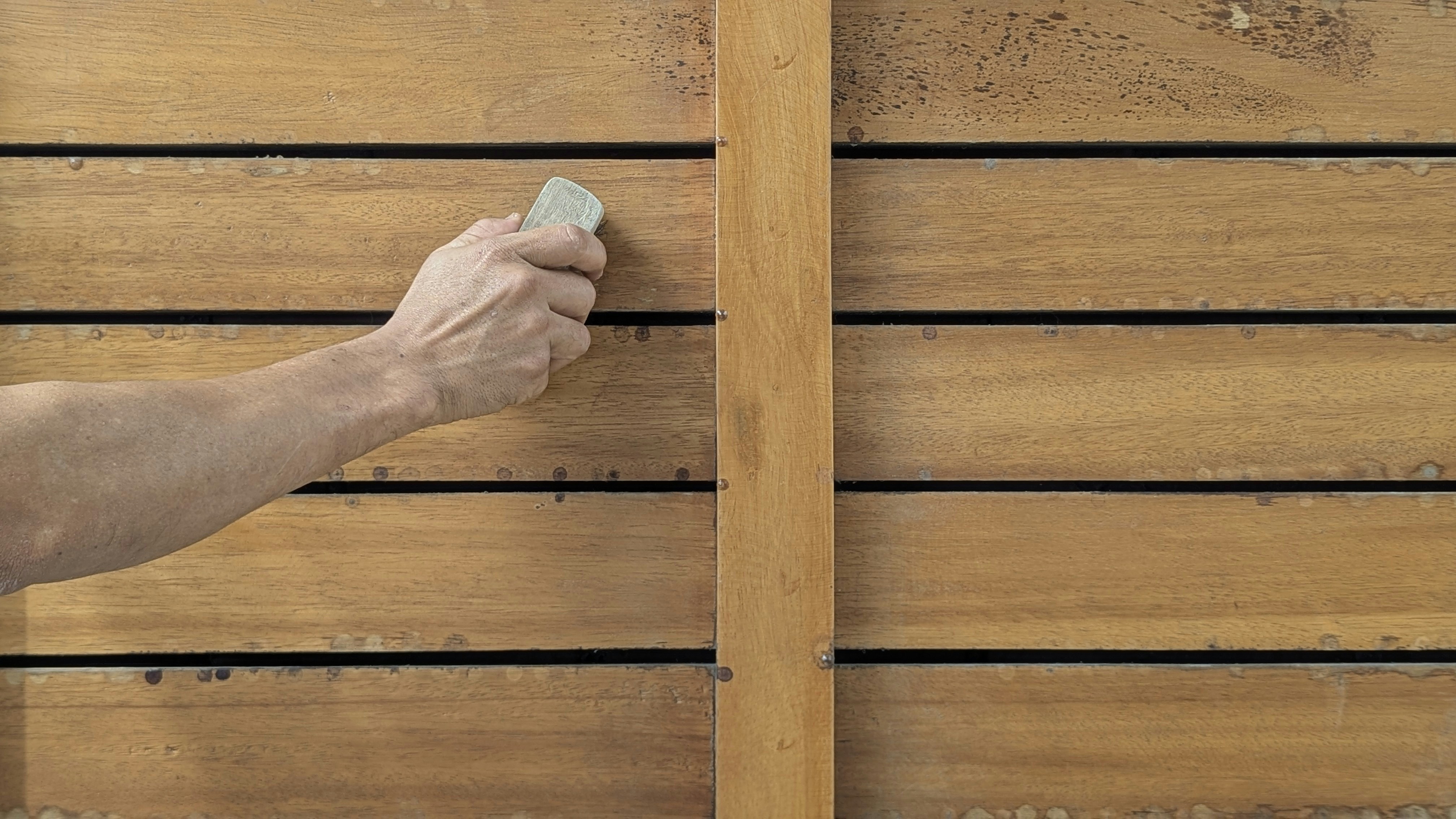 Chisel and Plank: Hand at Work on Wooden Slats