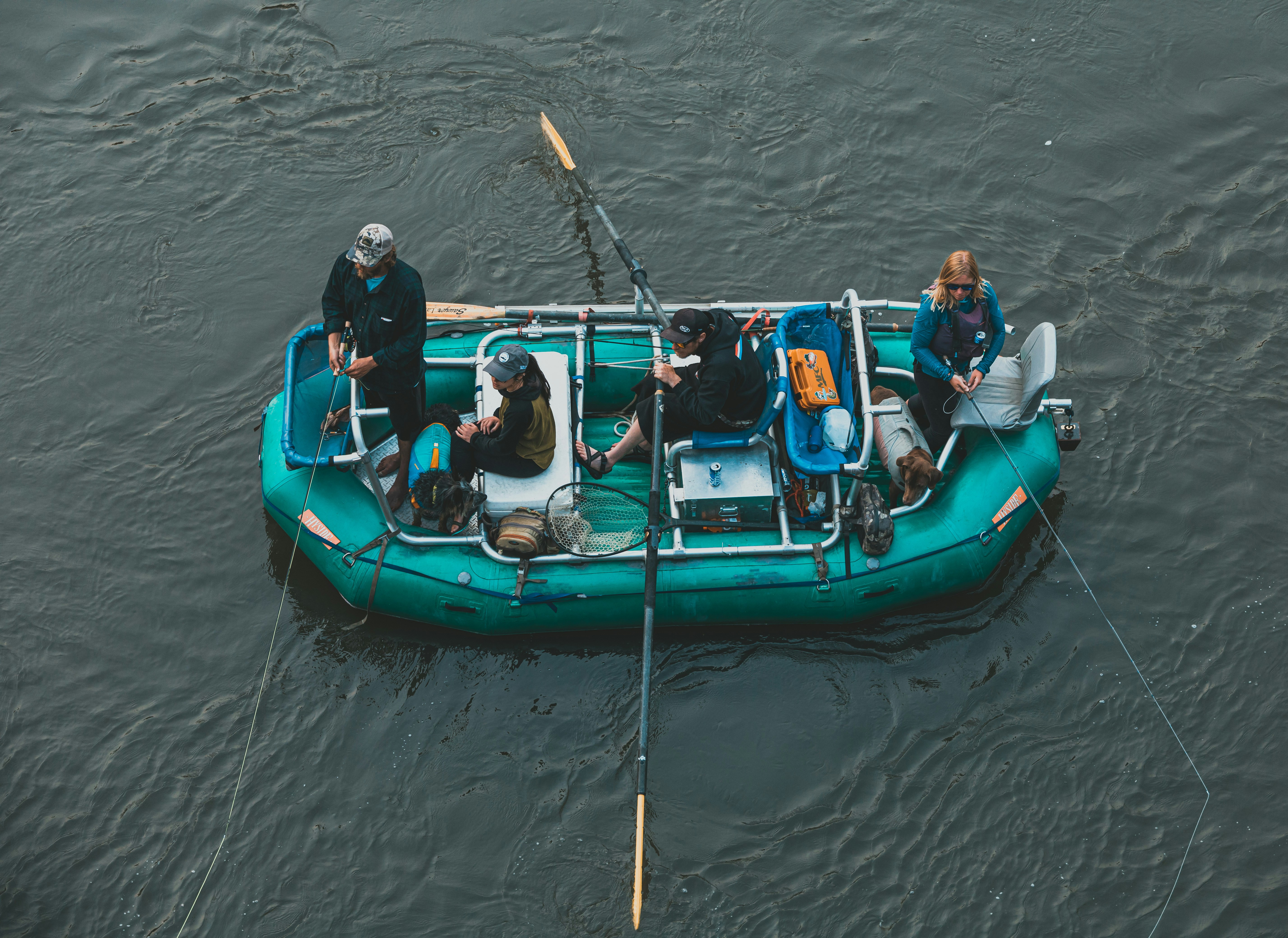 Overhead View: A Blue Inflatable Boat in Choppy Waters with Five Silent Rowers