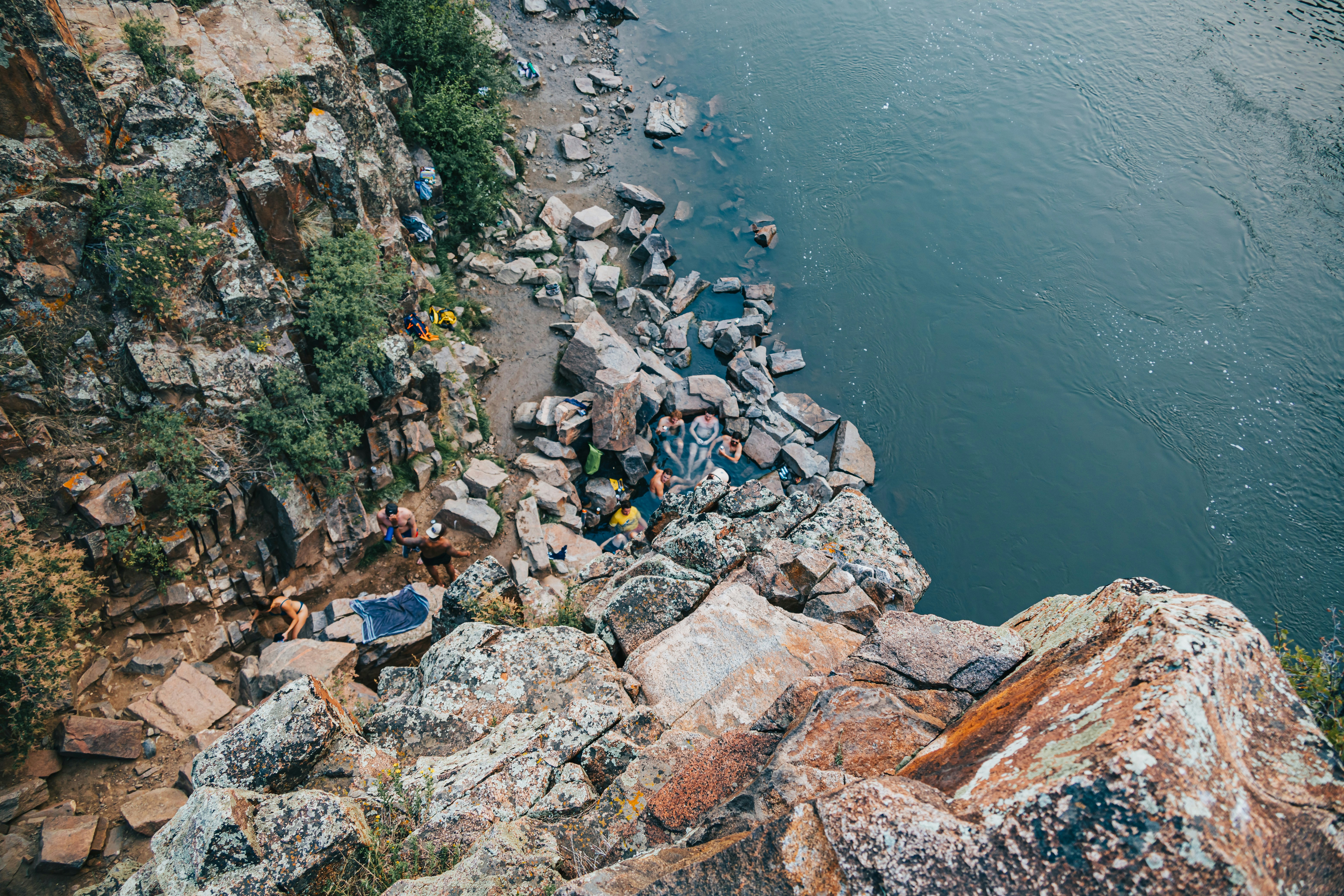 Rugged Cliffside Climb: Climbers Among Granite Tones by the River