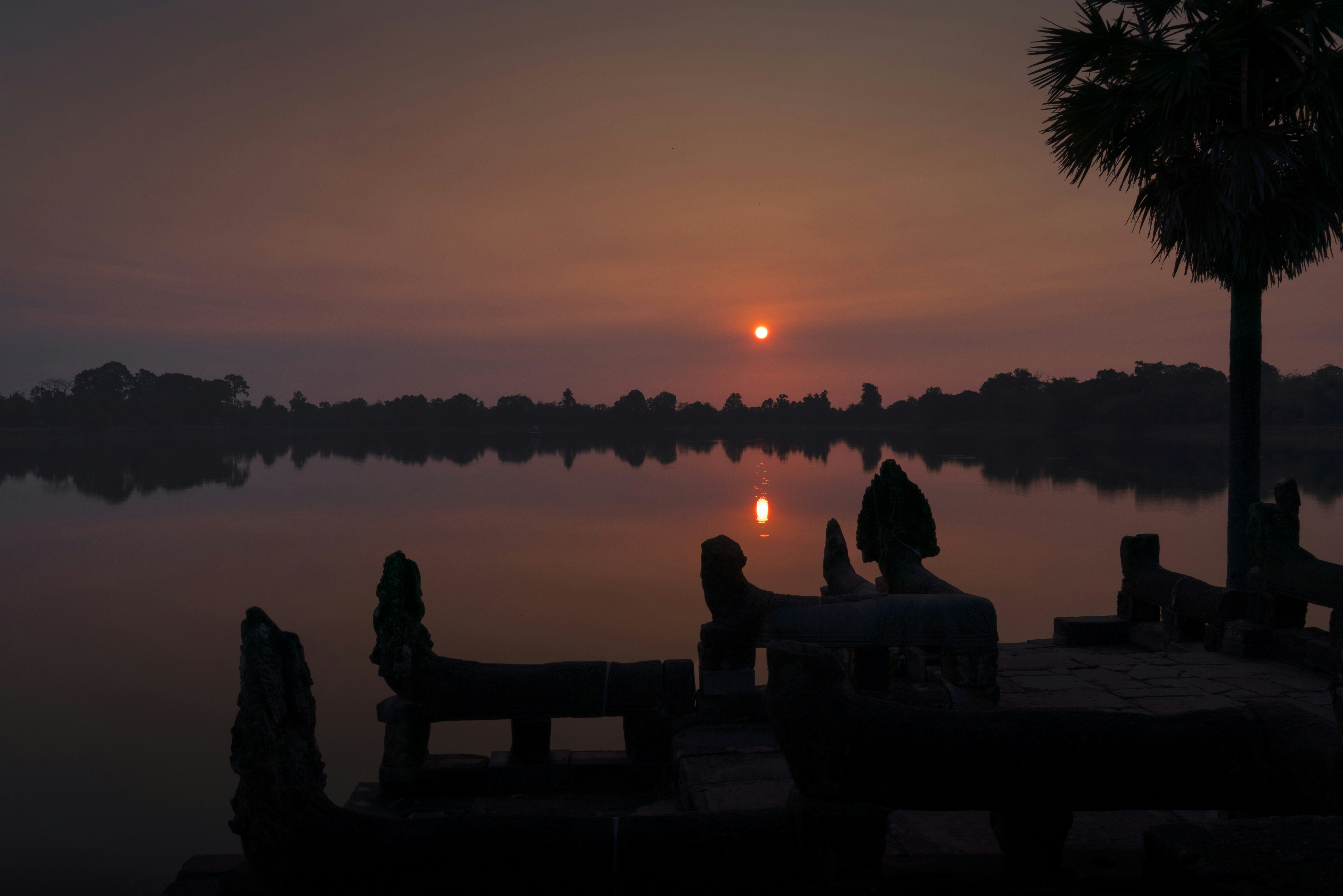 Sunrise over Angkor baray with stone naga balustrade