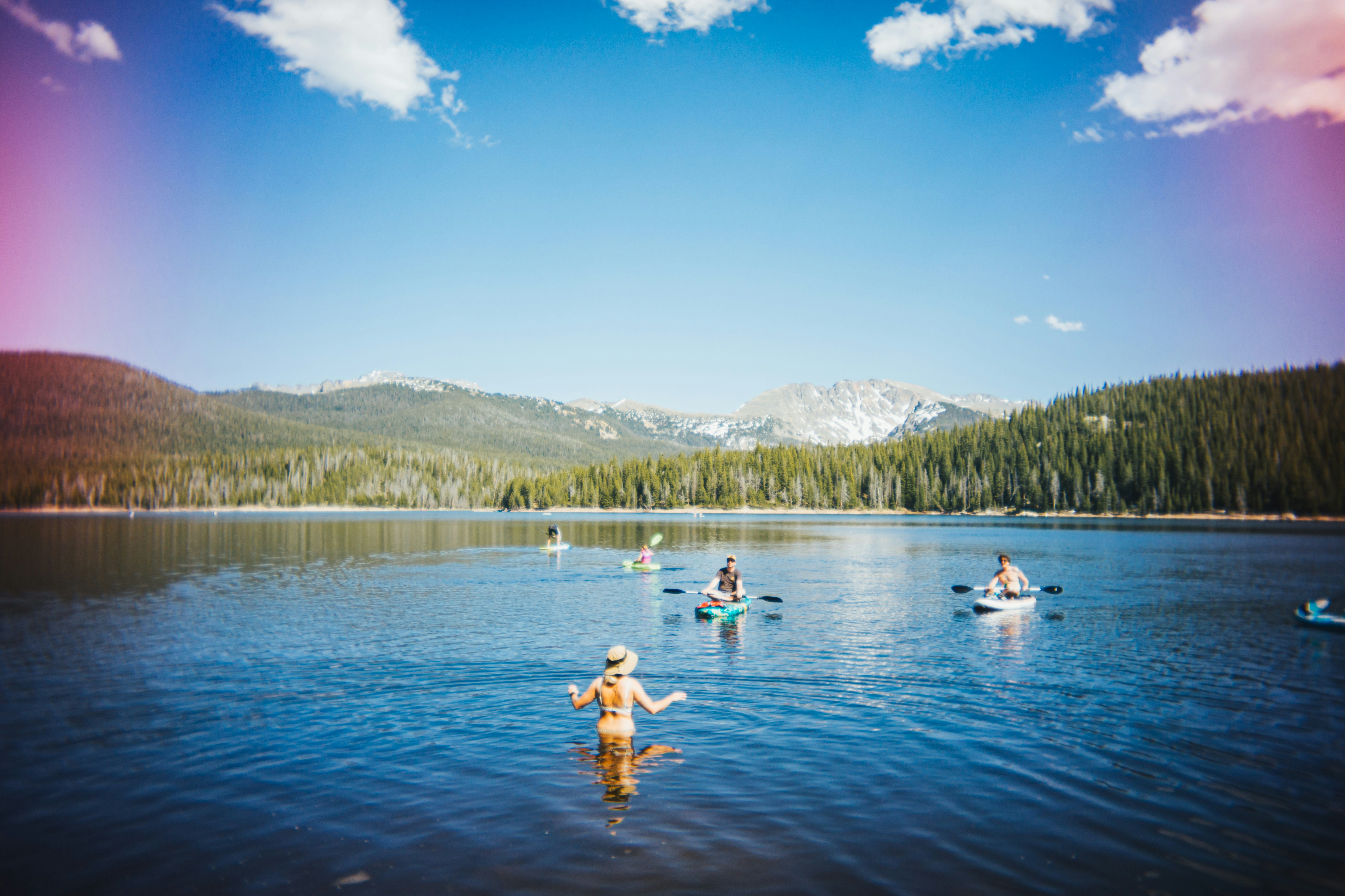 A Luminous Lake Parade: Children Splashing under a Rainbow-tinged Framing