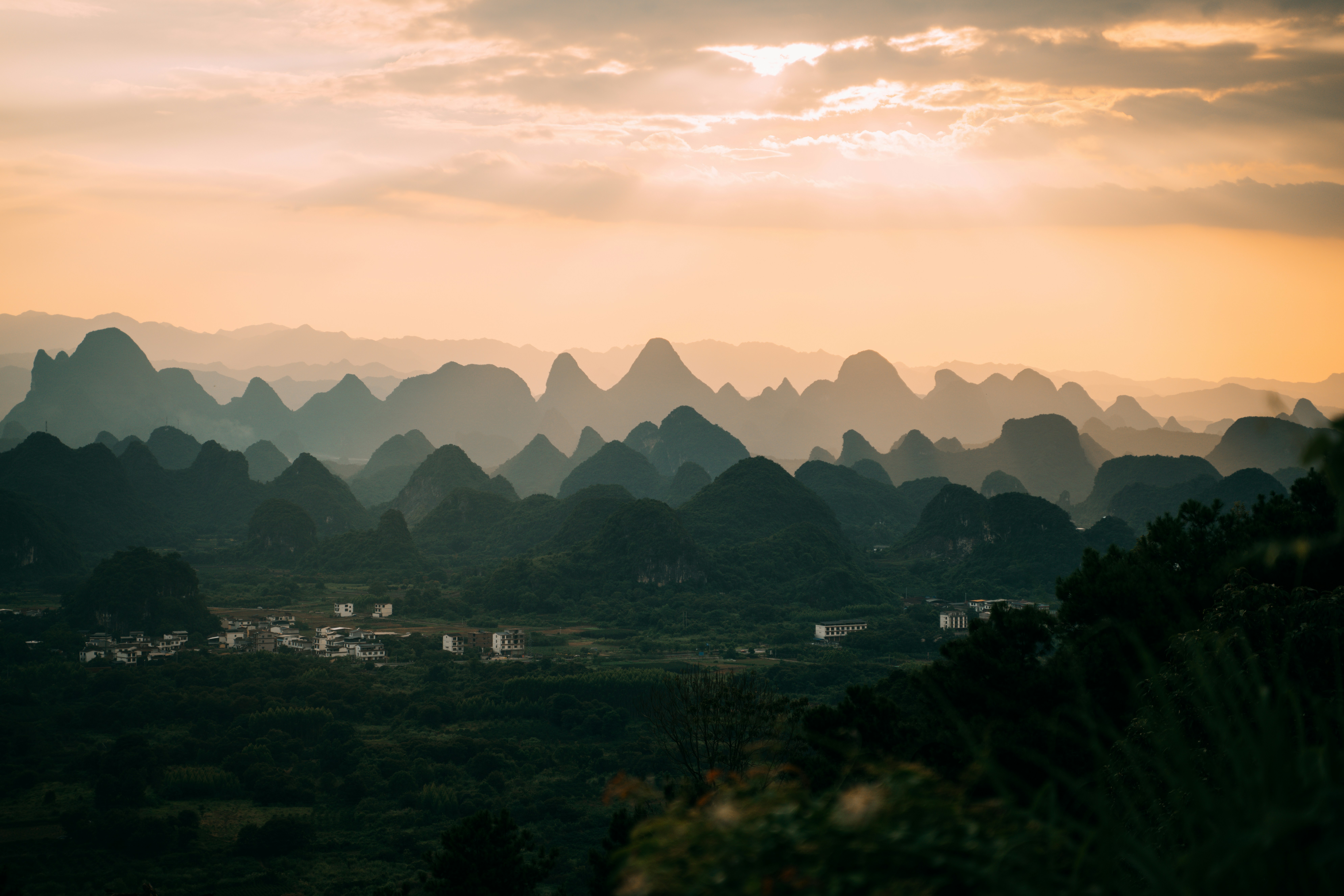 Silhouette of Karst Peaks at Dusk over a Quiet Valley