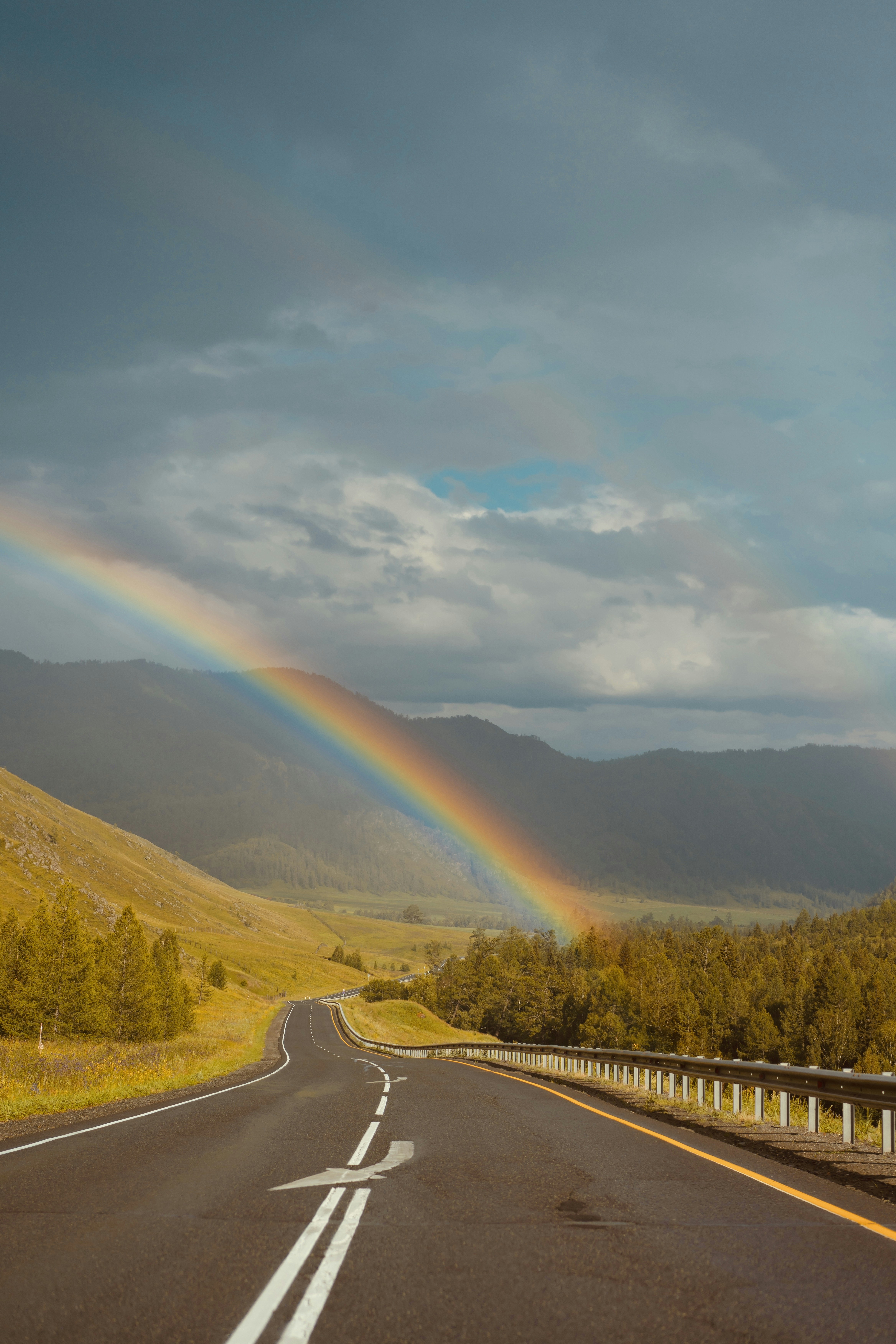 Rainbow Arc over an Open Mountain Road