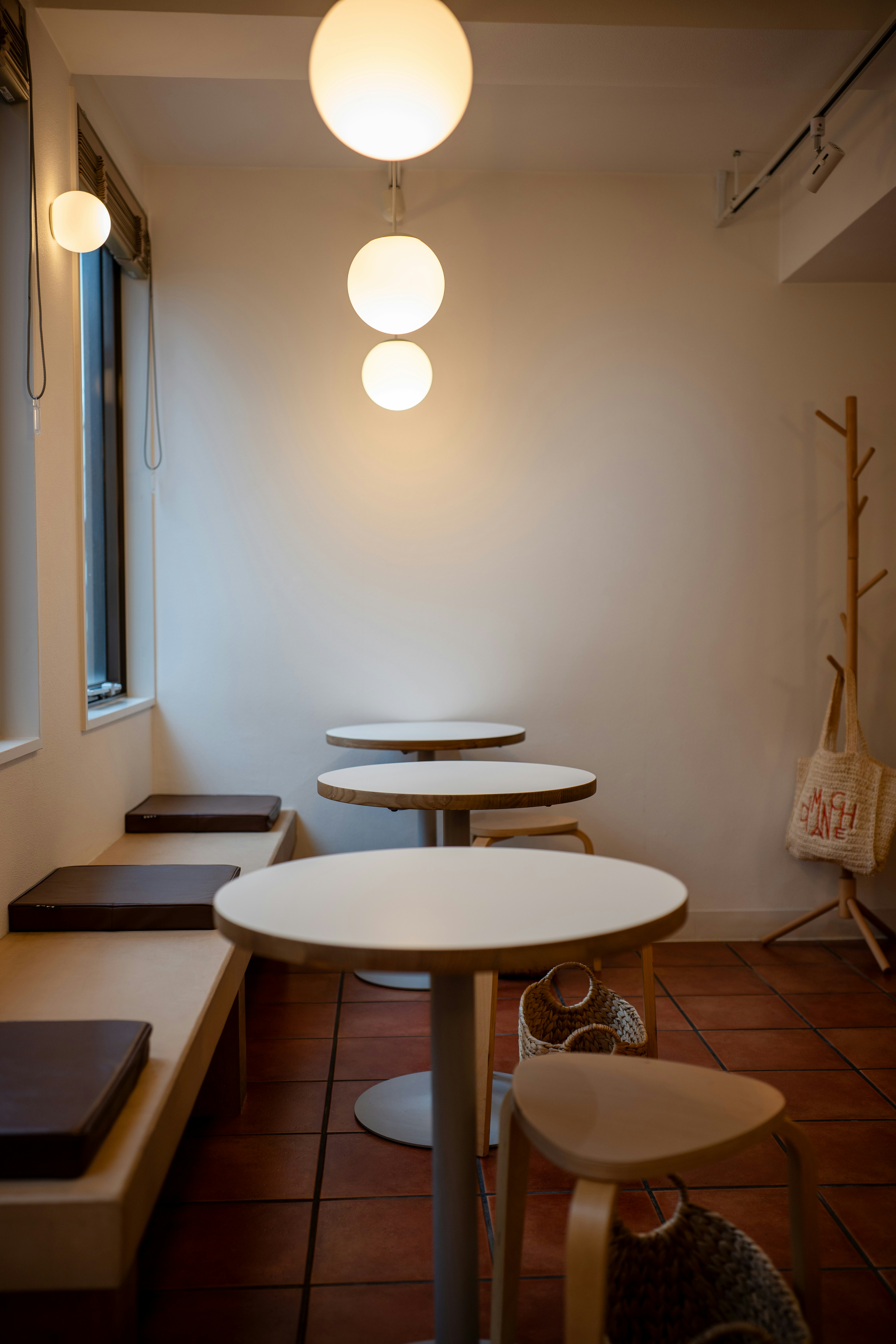 Quiet Café Corners: Soft Light and Round Tables in a Minimal Interior