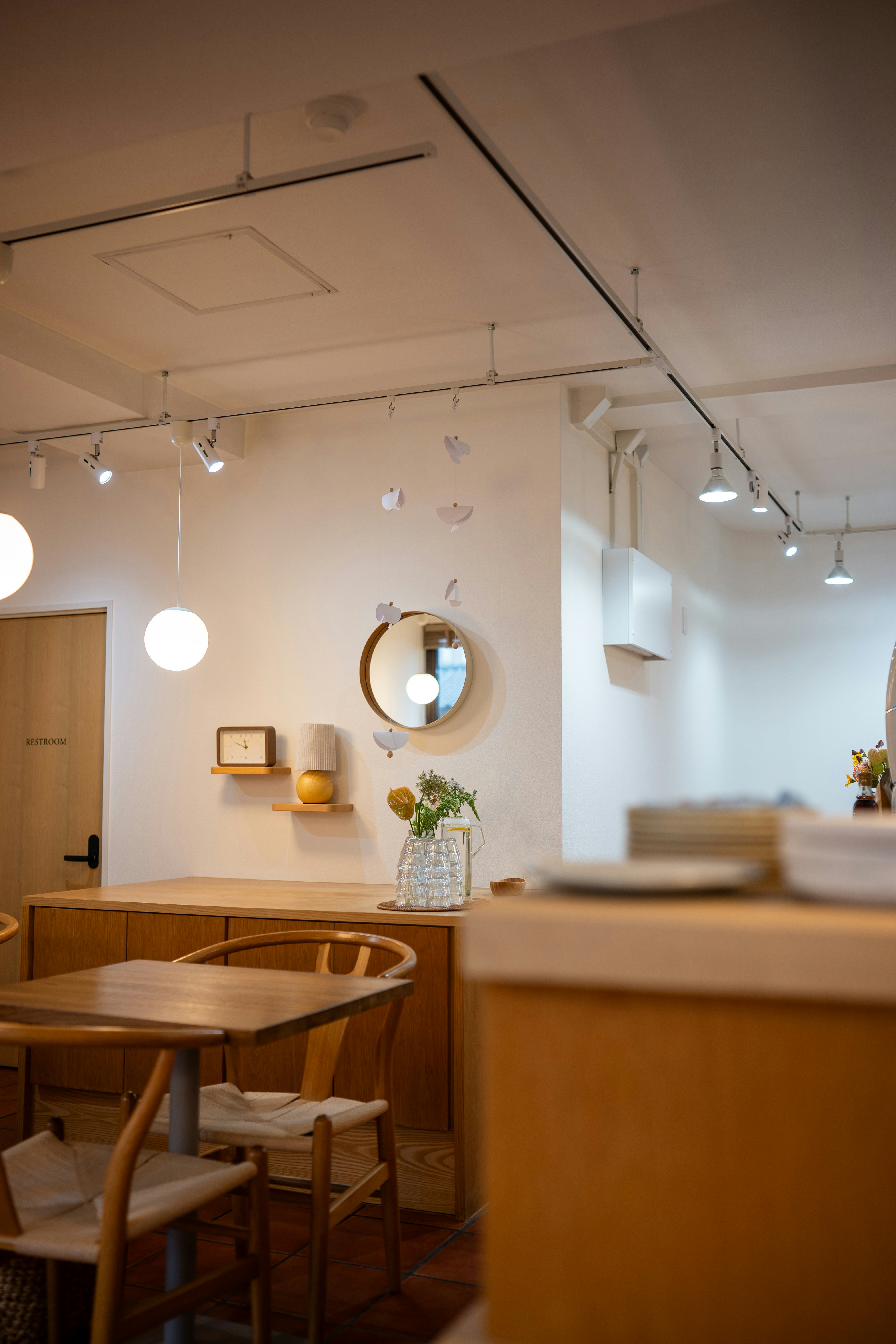 Softly Lit Café Interior with Circular Mirror and Floating Ornaments