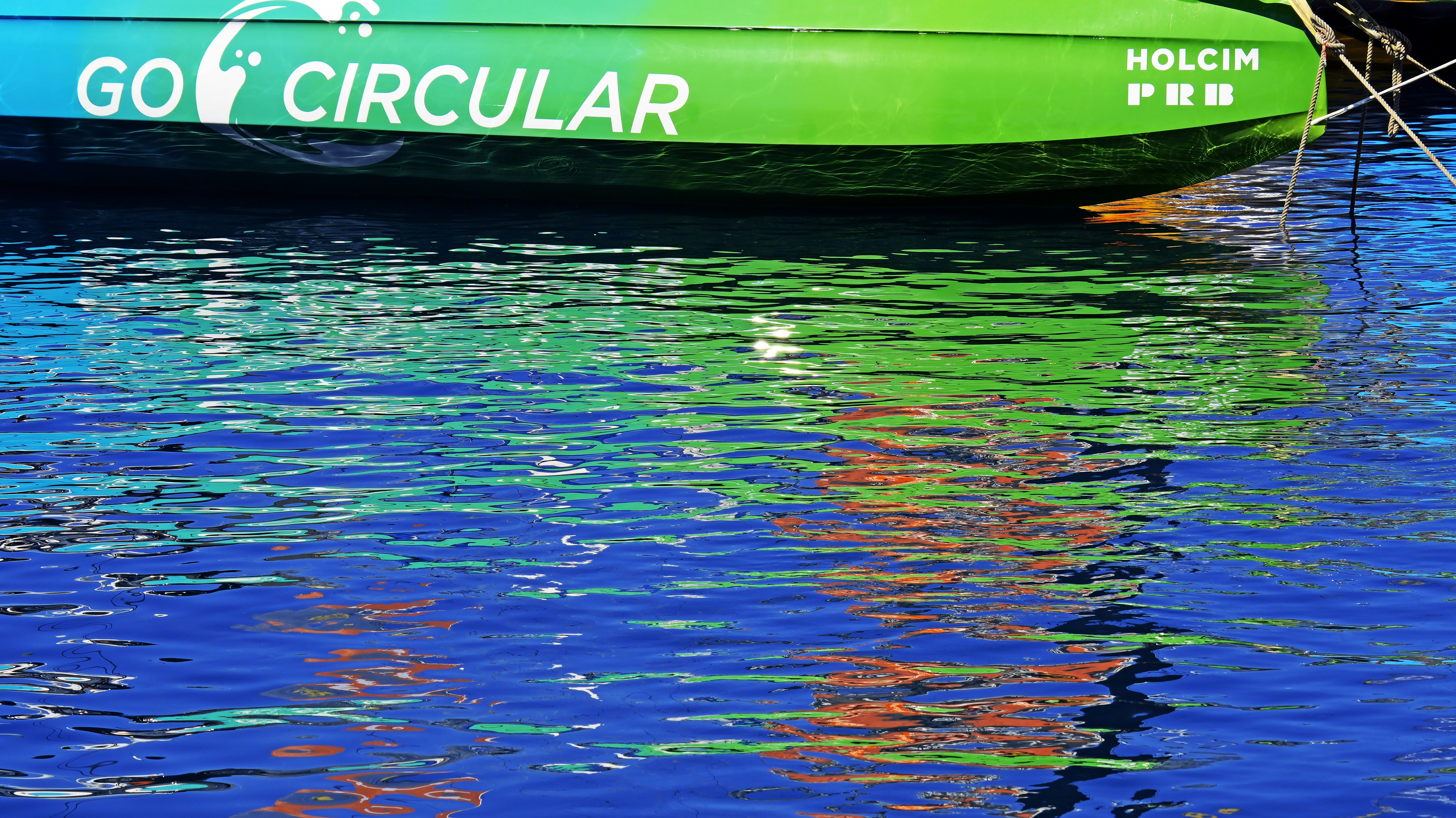 Emerald Wake: A Green Boat against Prismatic Water