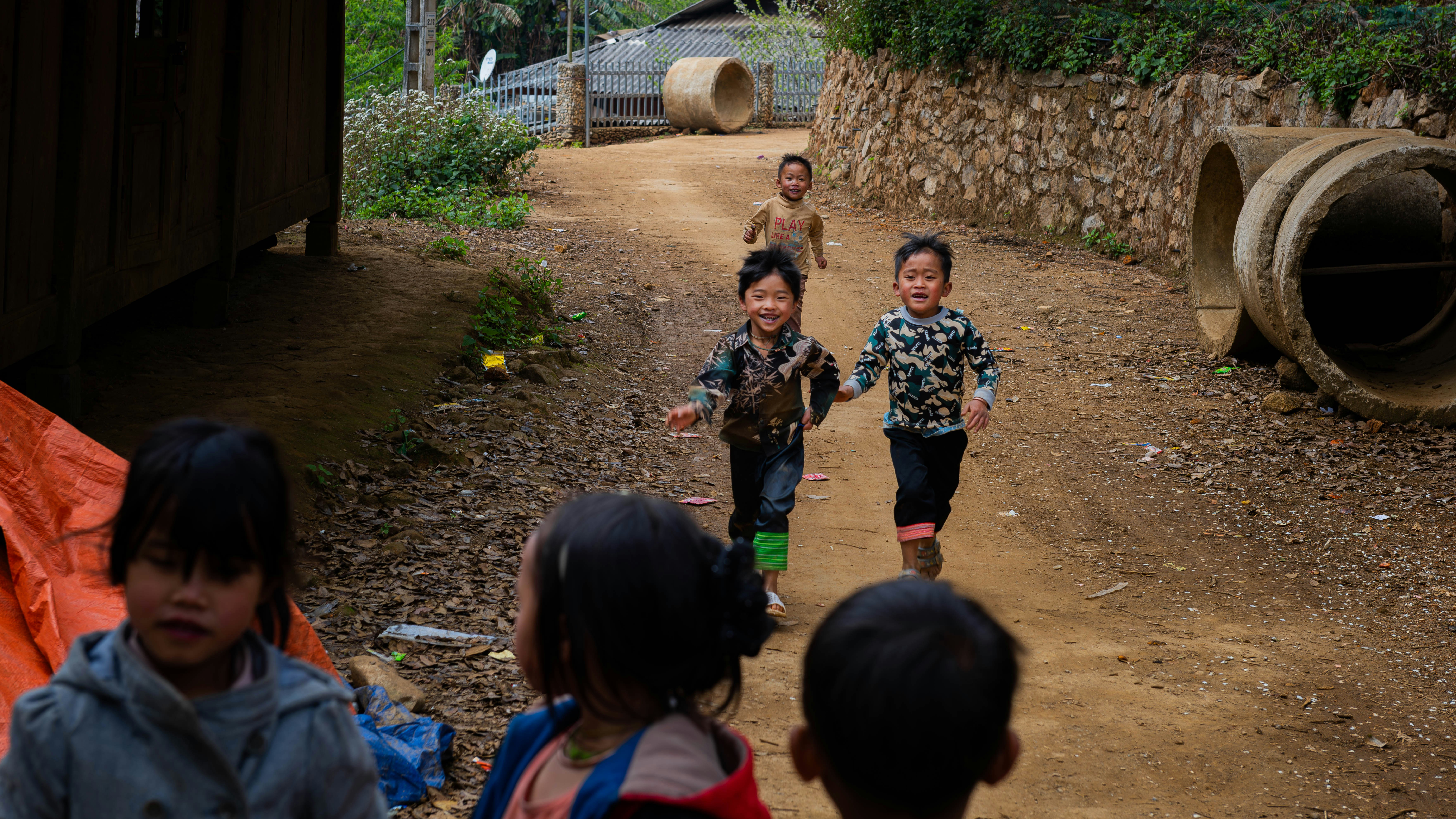 Dusty Yard Dash: Three Kids Chase Toward the Camera