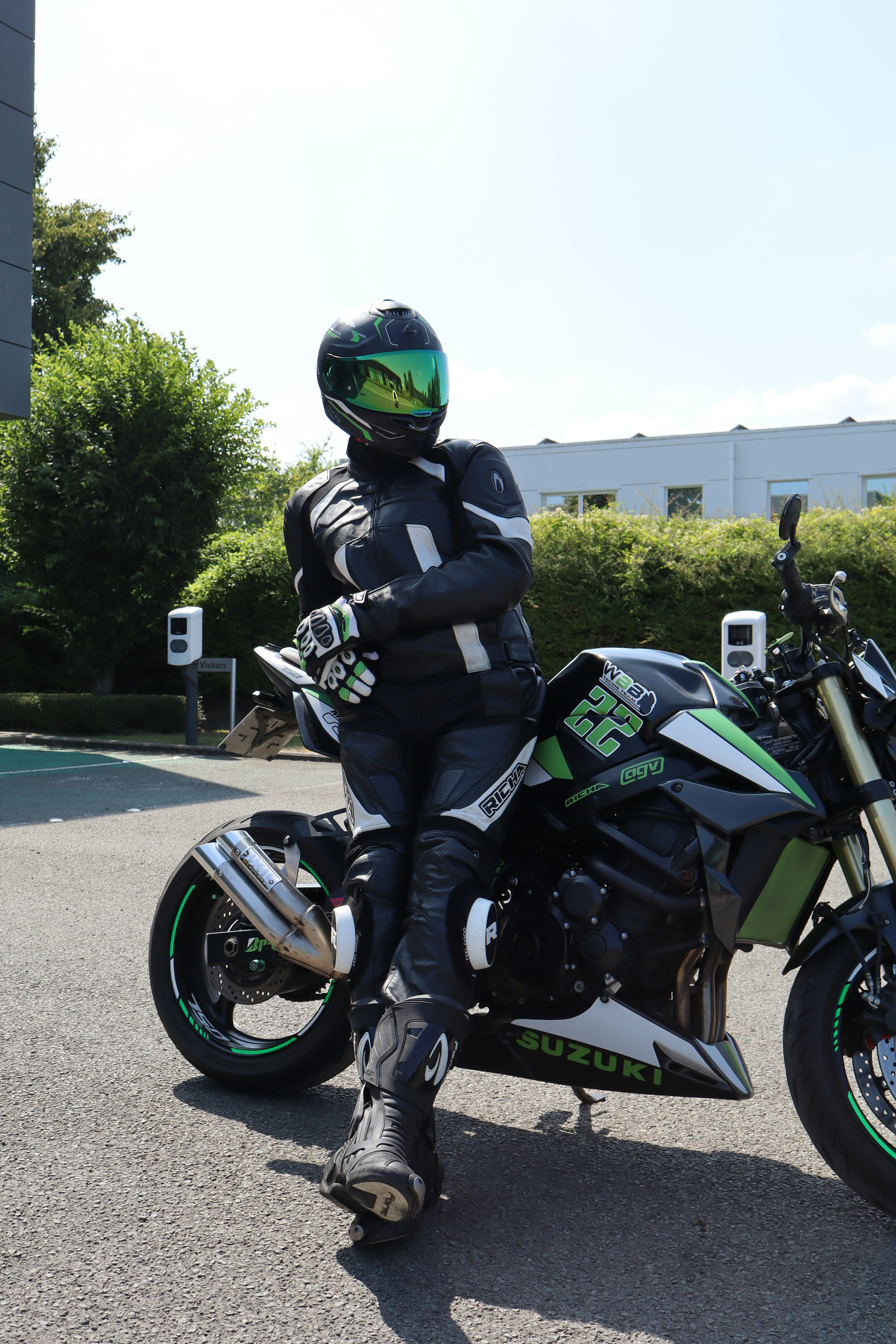 Rider at Rest: Green and Black Suzuki Stands Out in Sunlit Depot