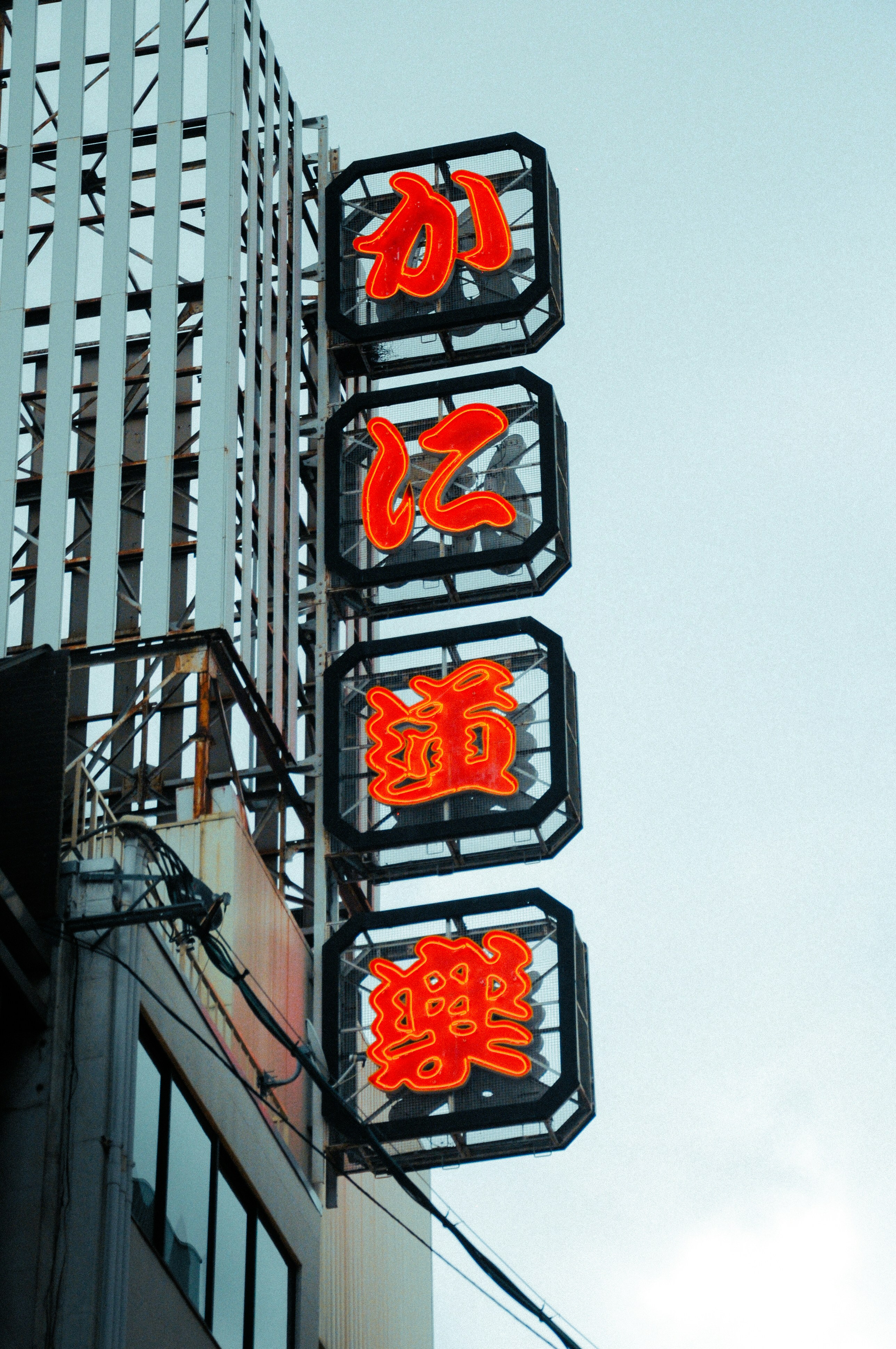 Neon Gateways: Vertical Mandarin Sign on a Weathered Facade