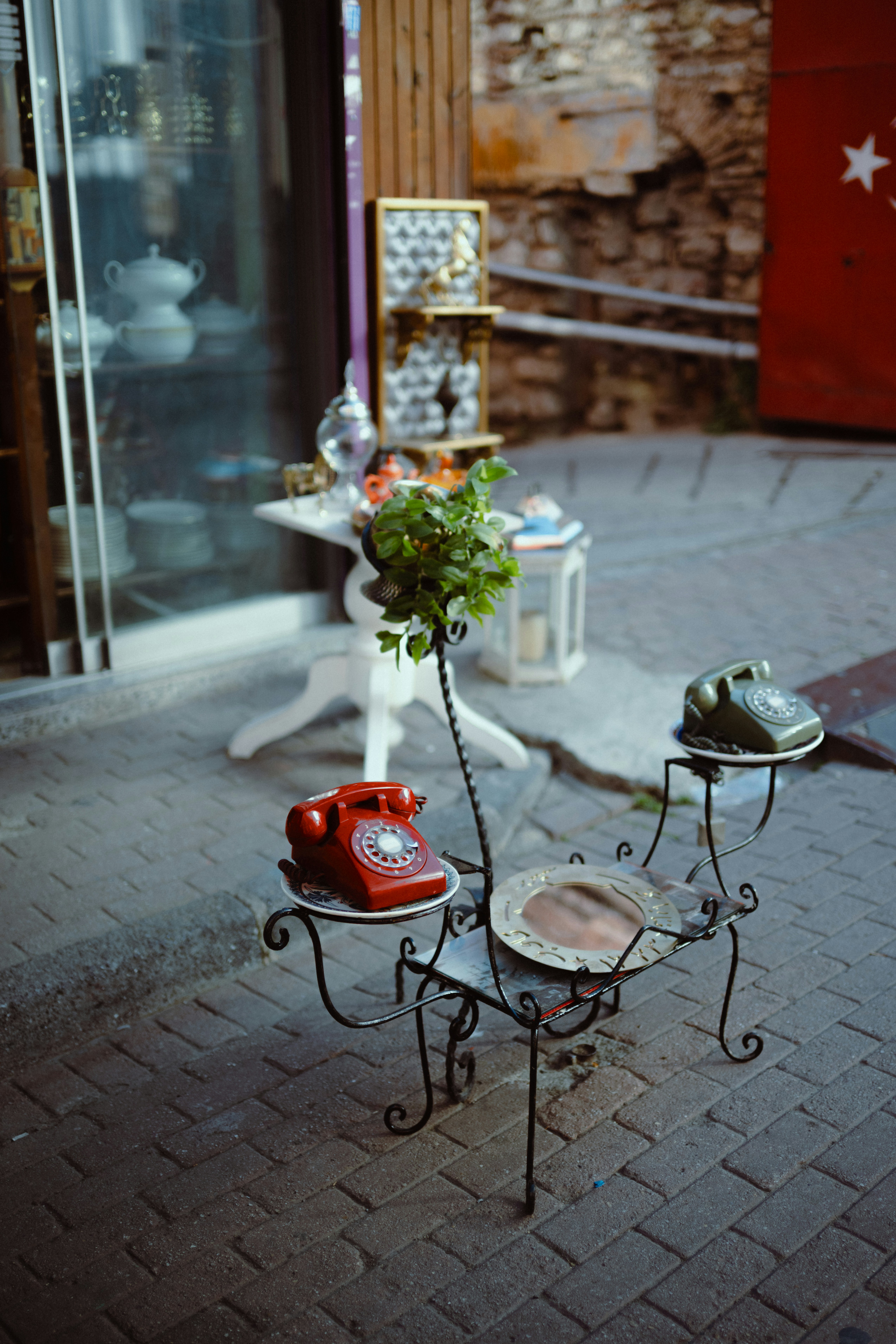 Old-fashioned Dial and Greenery: a Quiet Street Corner with a Red Rotary Desk Phone
