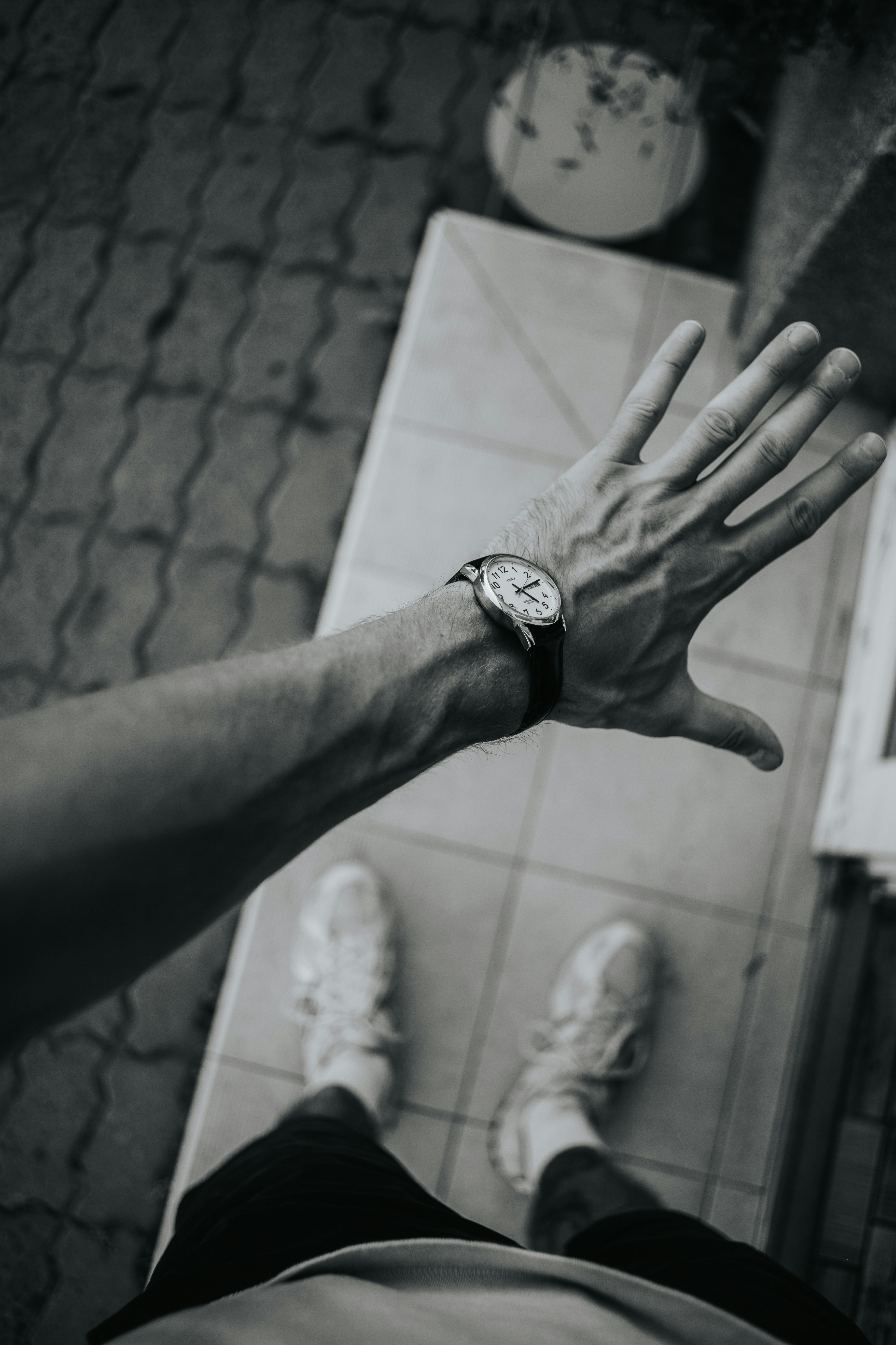 Outstretched Hand and Wristwatch: A Ground-Level Climb Toward Time