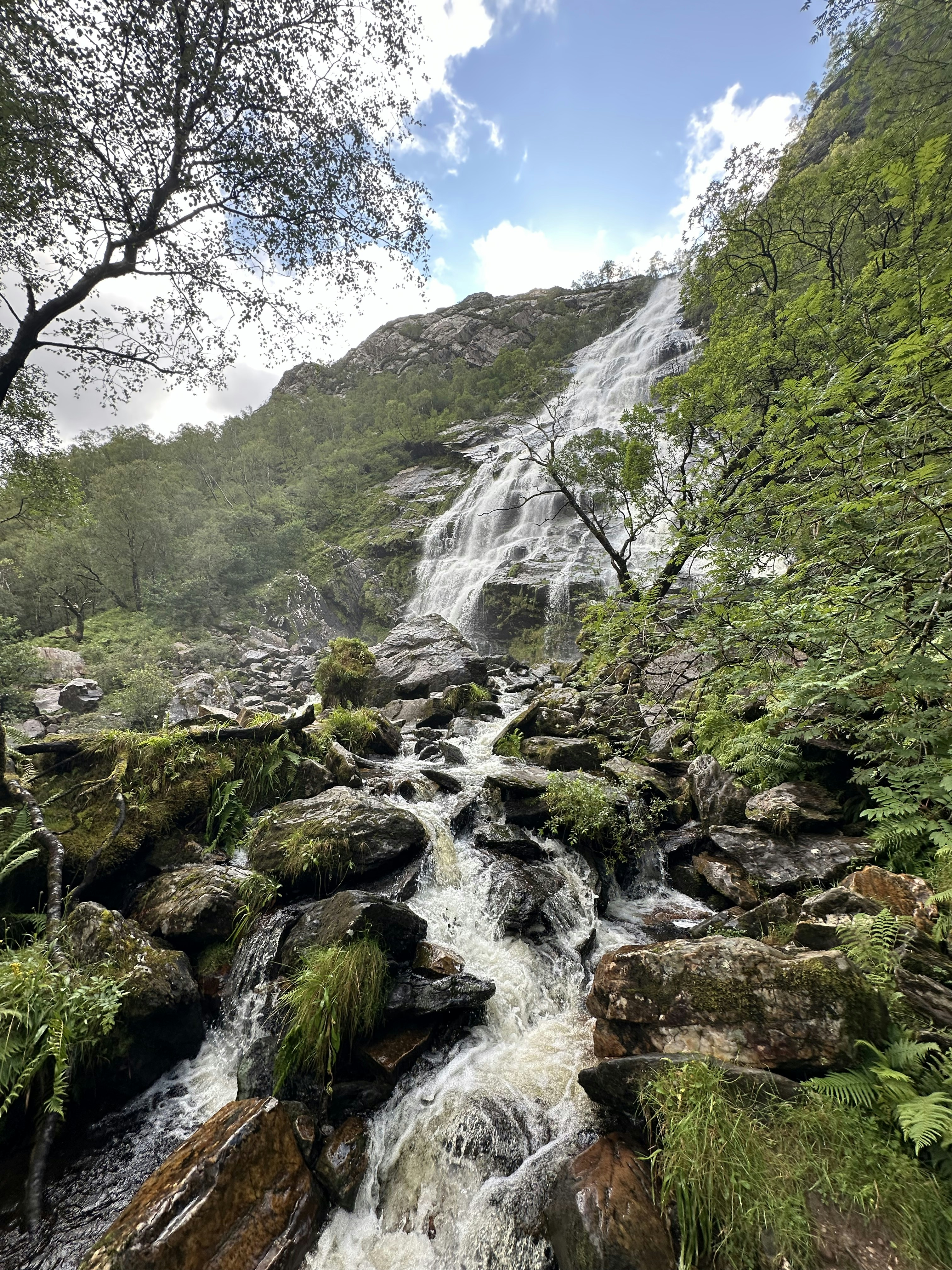 Cascade Crown: A Mountain Stream Dwarfed by a Far-reaching Waterfall