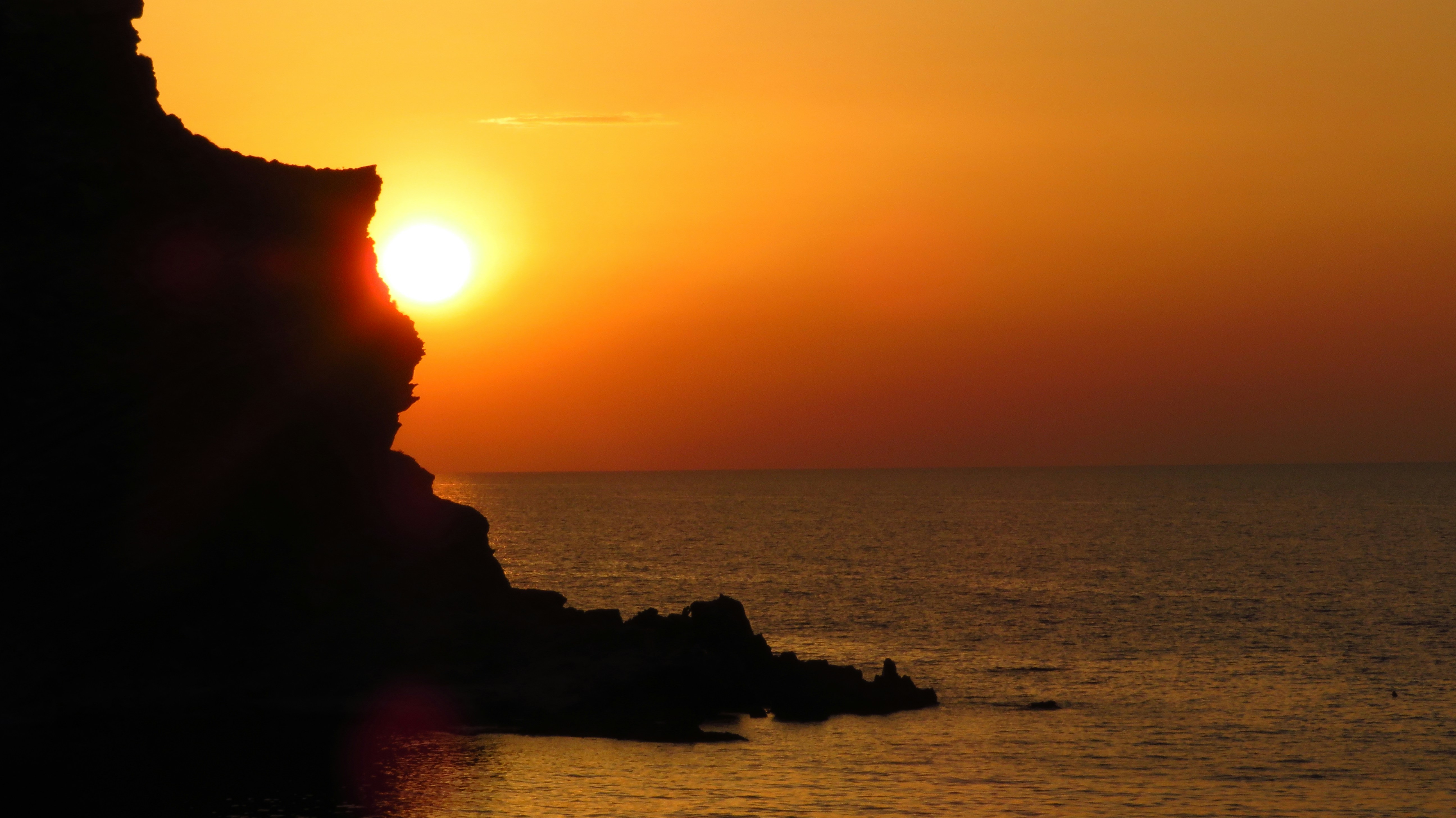 Sunlit Cliff at Dusk: Quiet Horizon Over Calm Waters