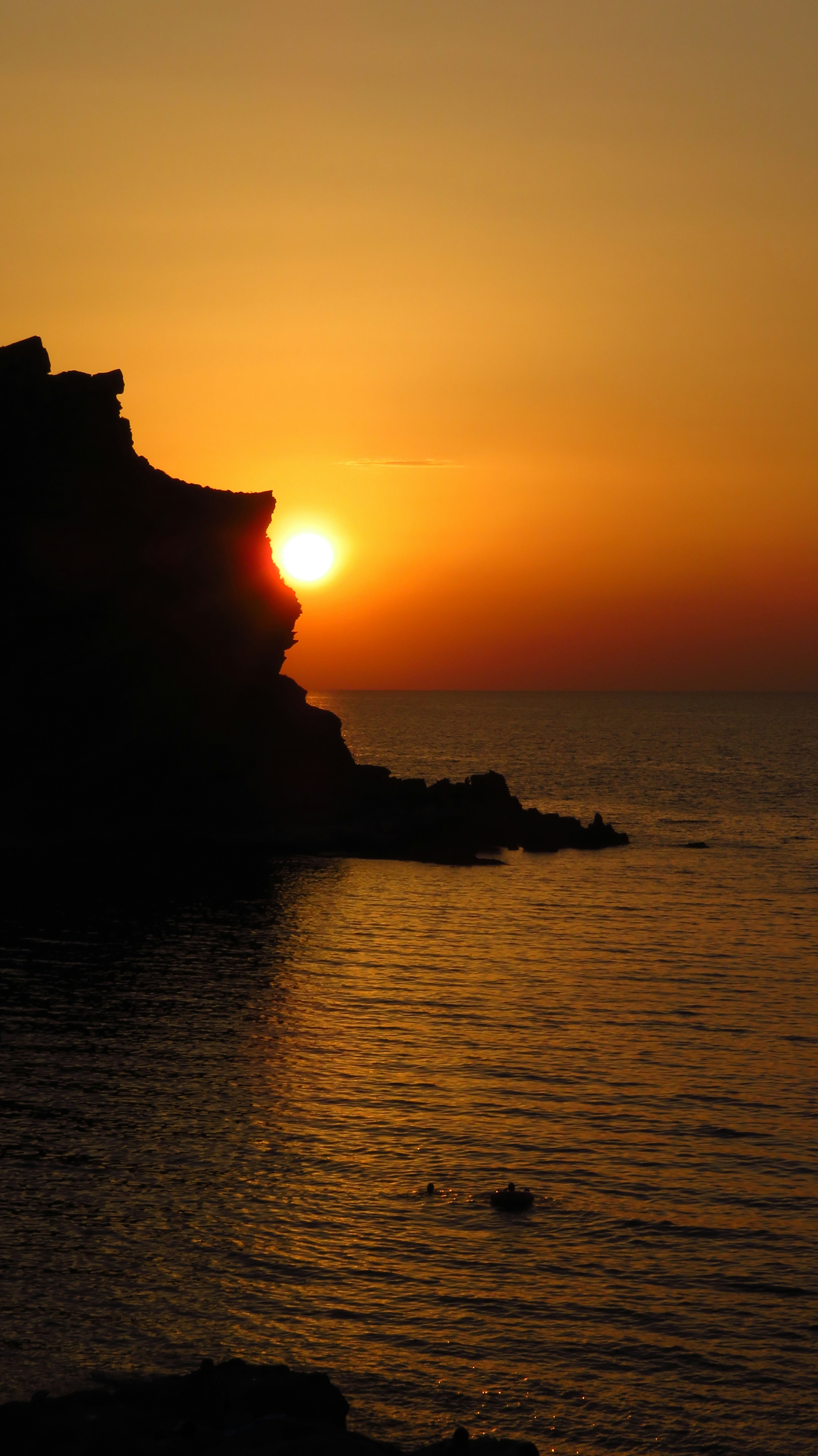 Sunset Over Silhouette: A Quiet Cliff Meeting the Sea