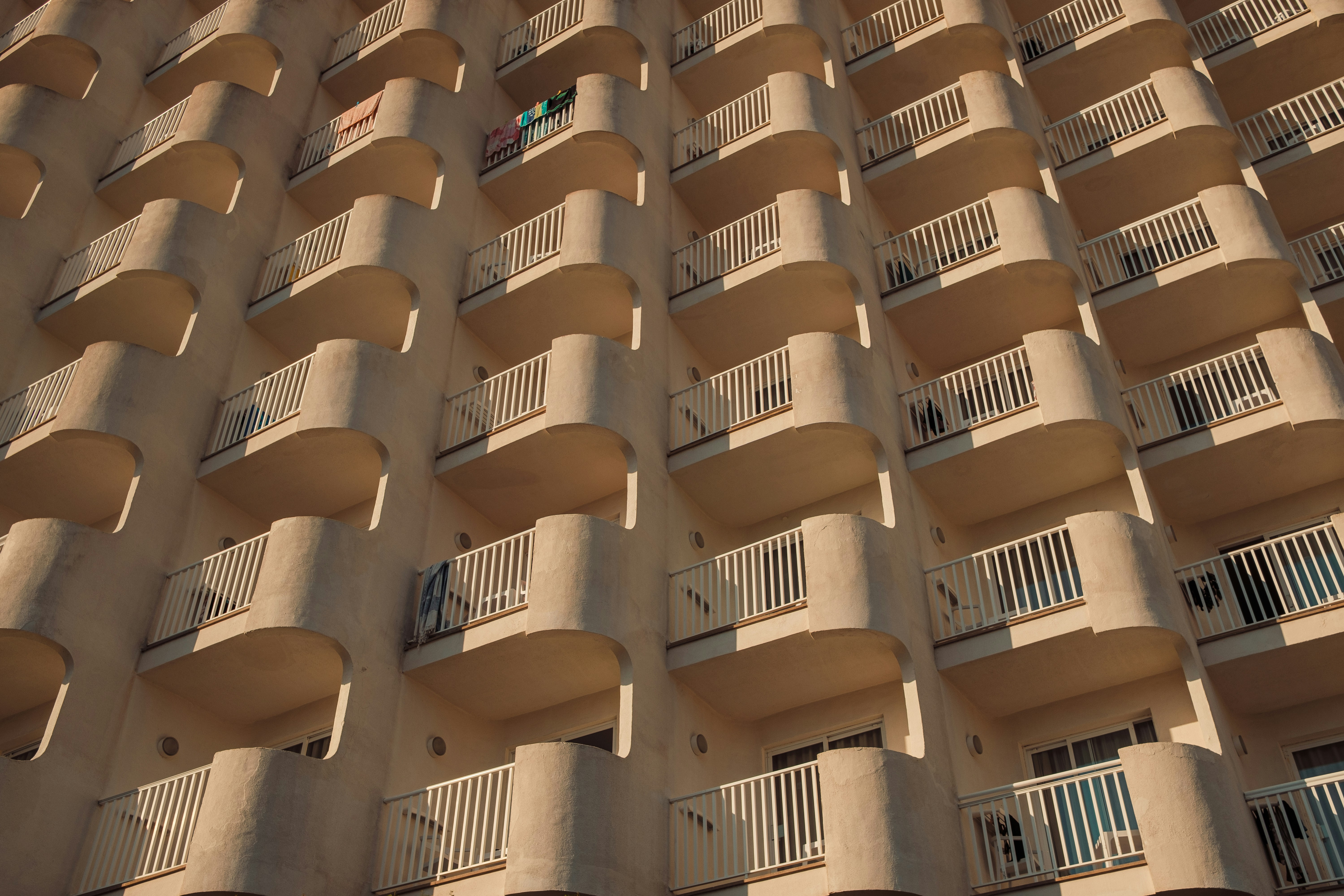 Repeating Concrete Verandas: A Sunlit Facade’s Geometric Rhythm