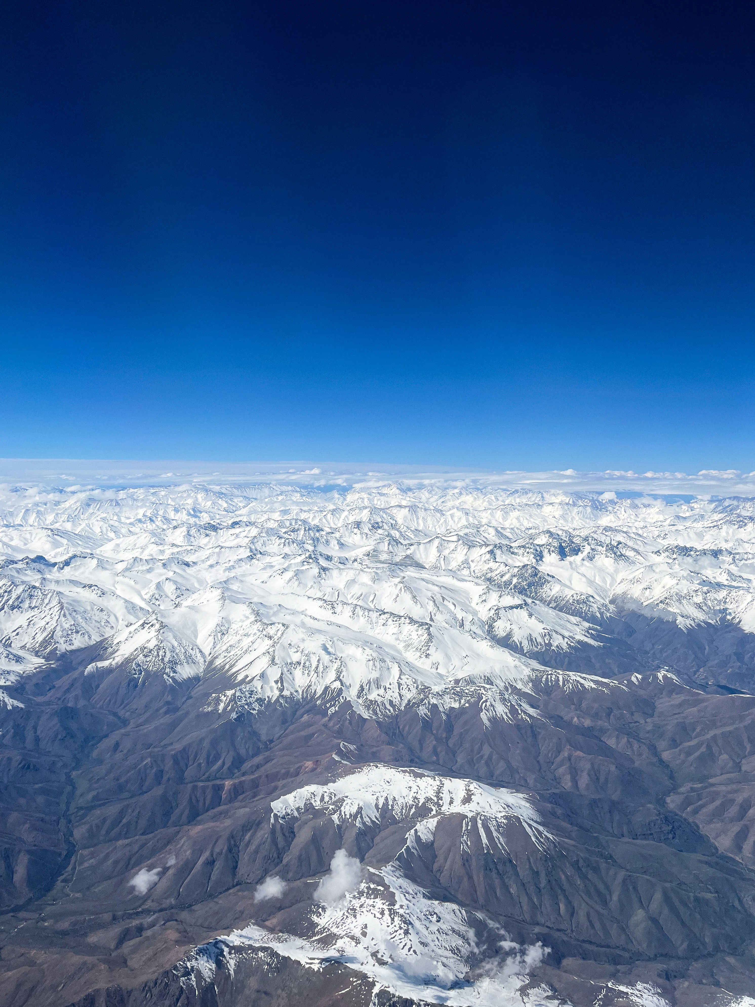 Aerial White Ridges: Snow-Dusted Peaks Beneath a Cerulean Sky