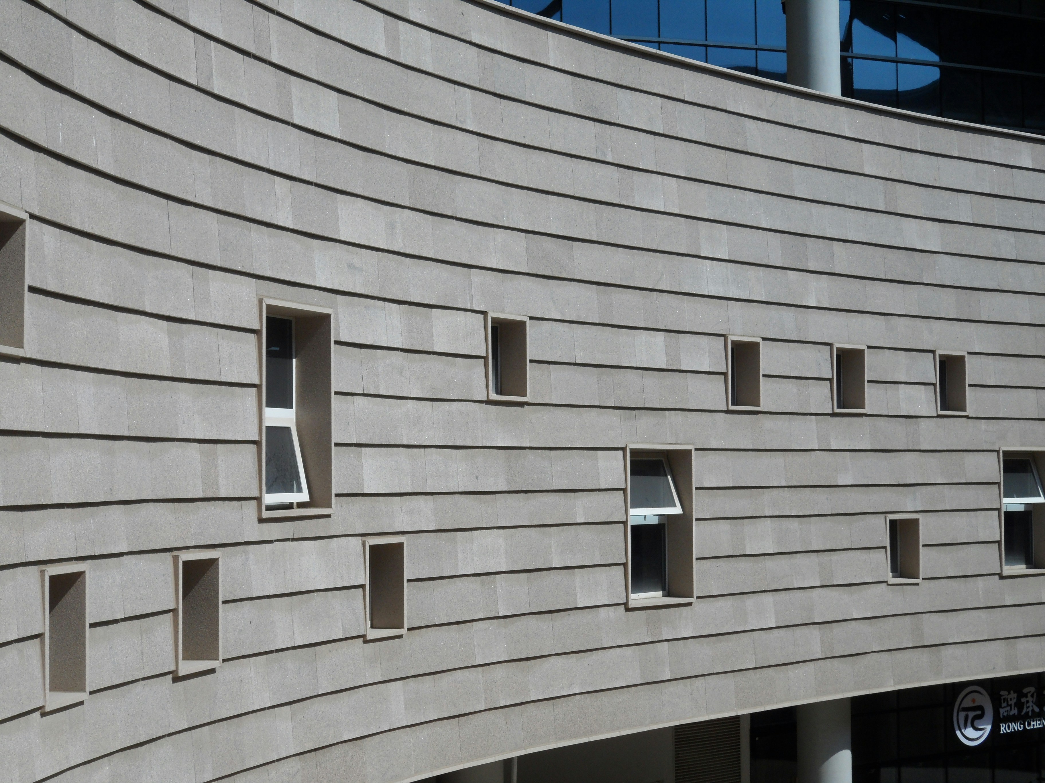 Curved Facade Echoes Light and Windows