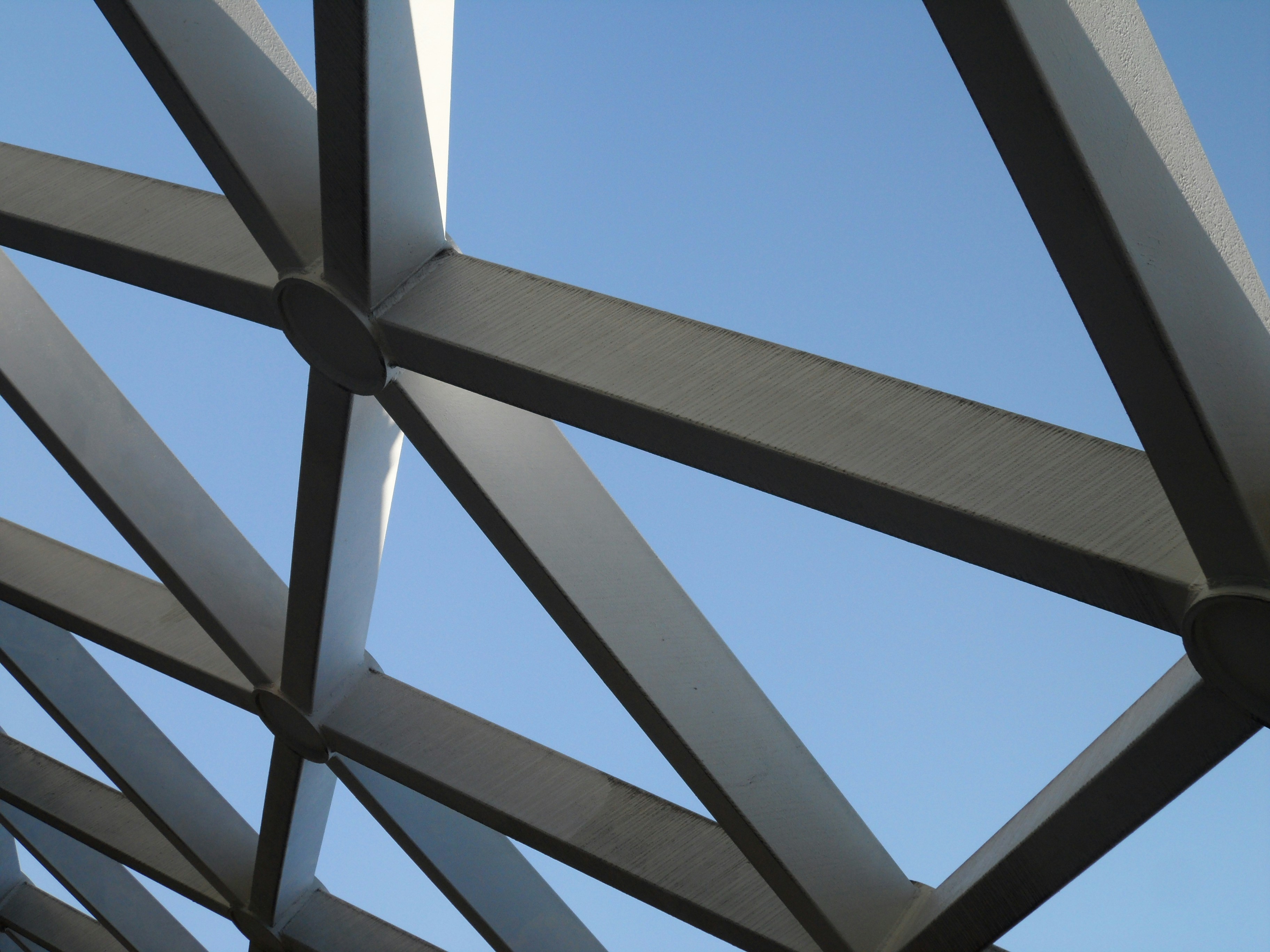 Geometric Skyward: Interlocking Steel Beams Against a Clear Blue
