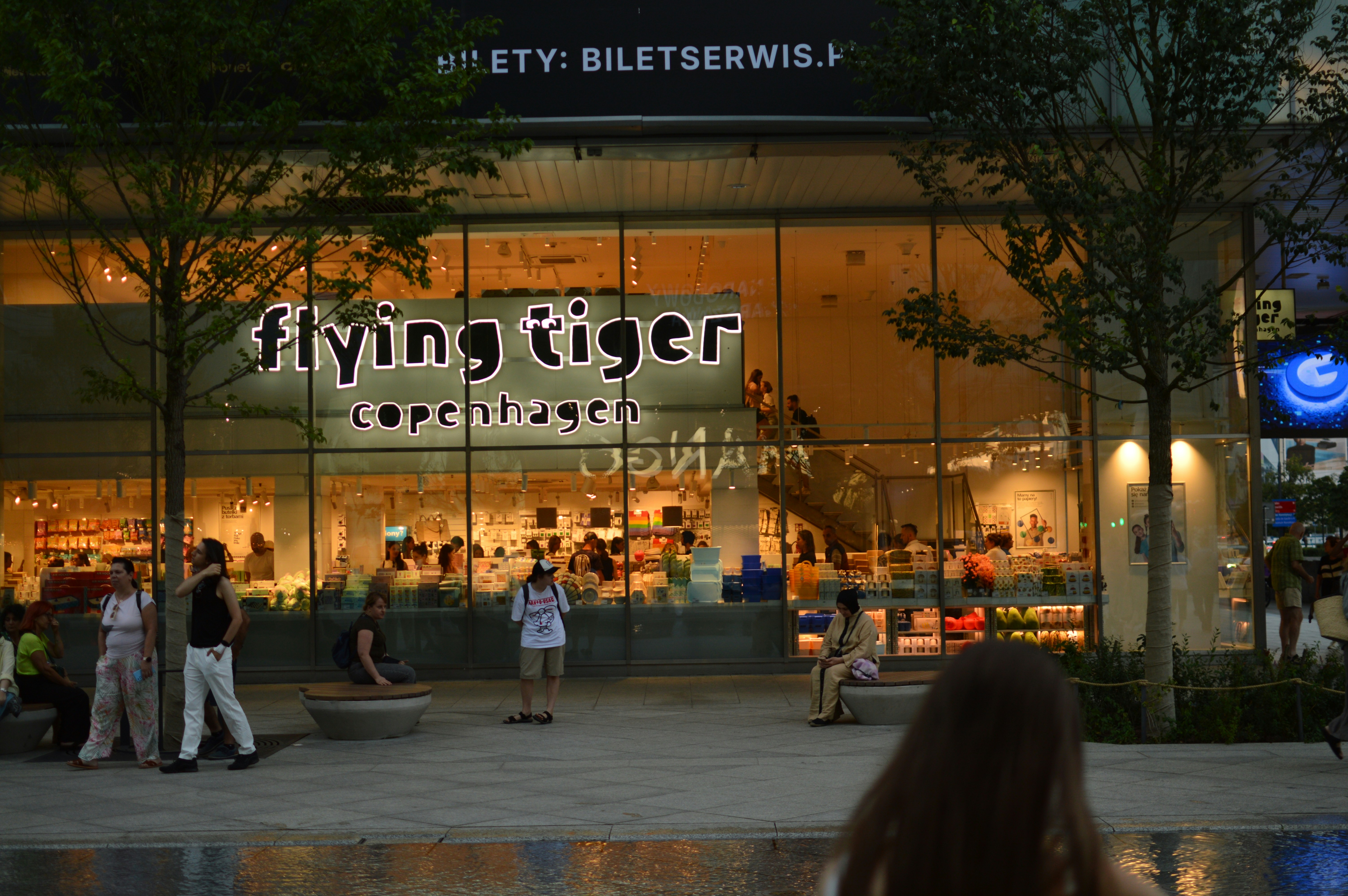 Lively Copenhagen storefront of Flying Tiger illuminated at dusk