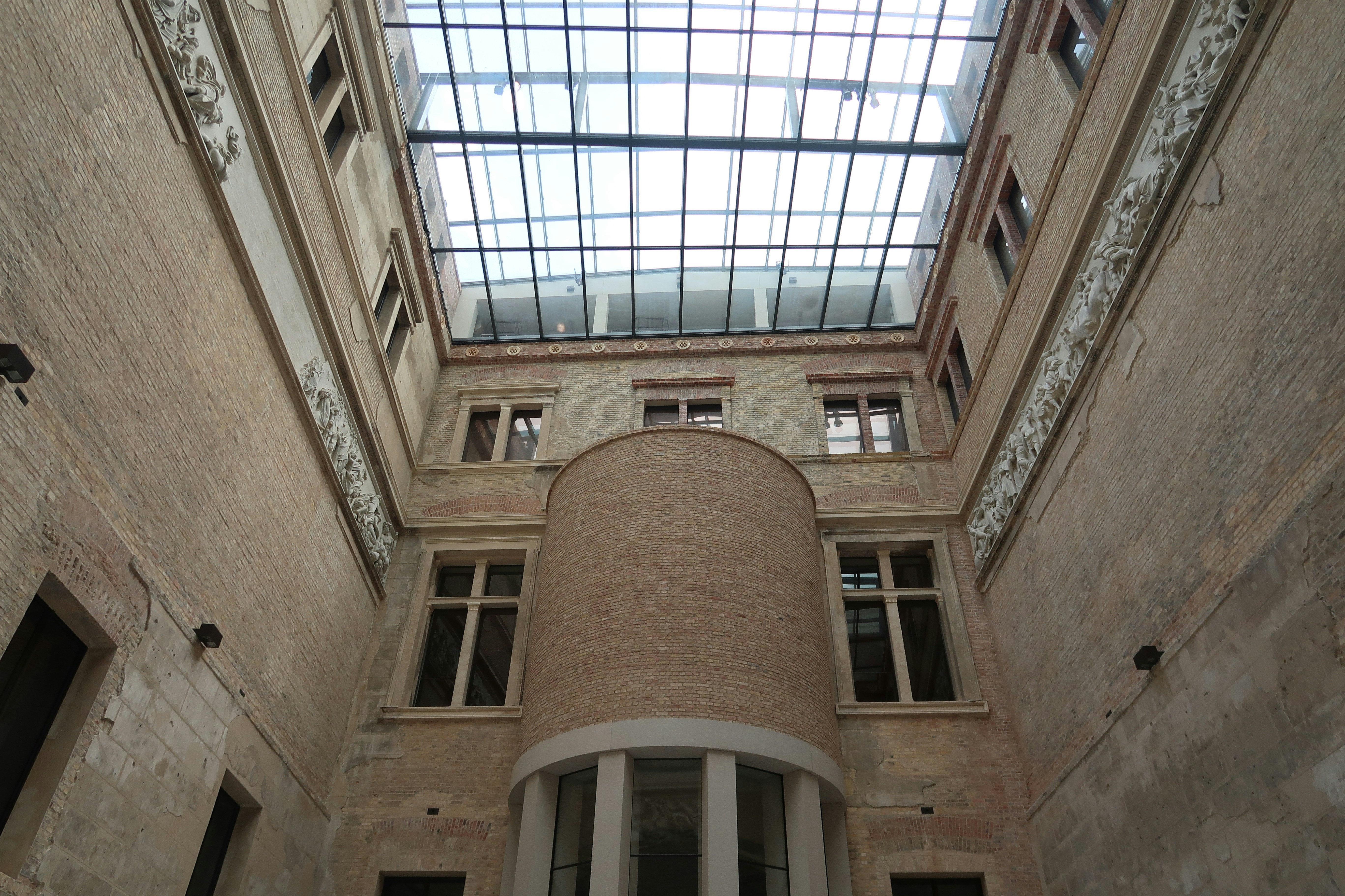 Atrium of Glass and Brick: A Central Cylindrical Core Reaching for the Skylight