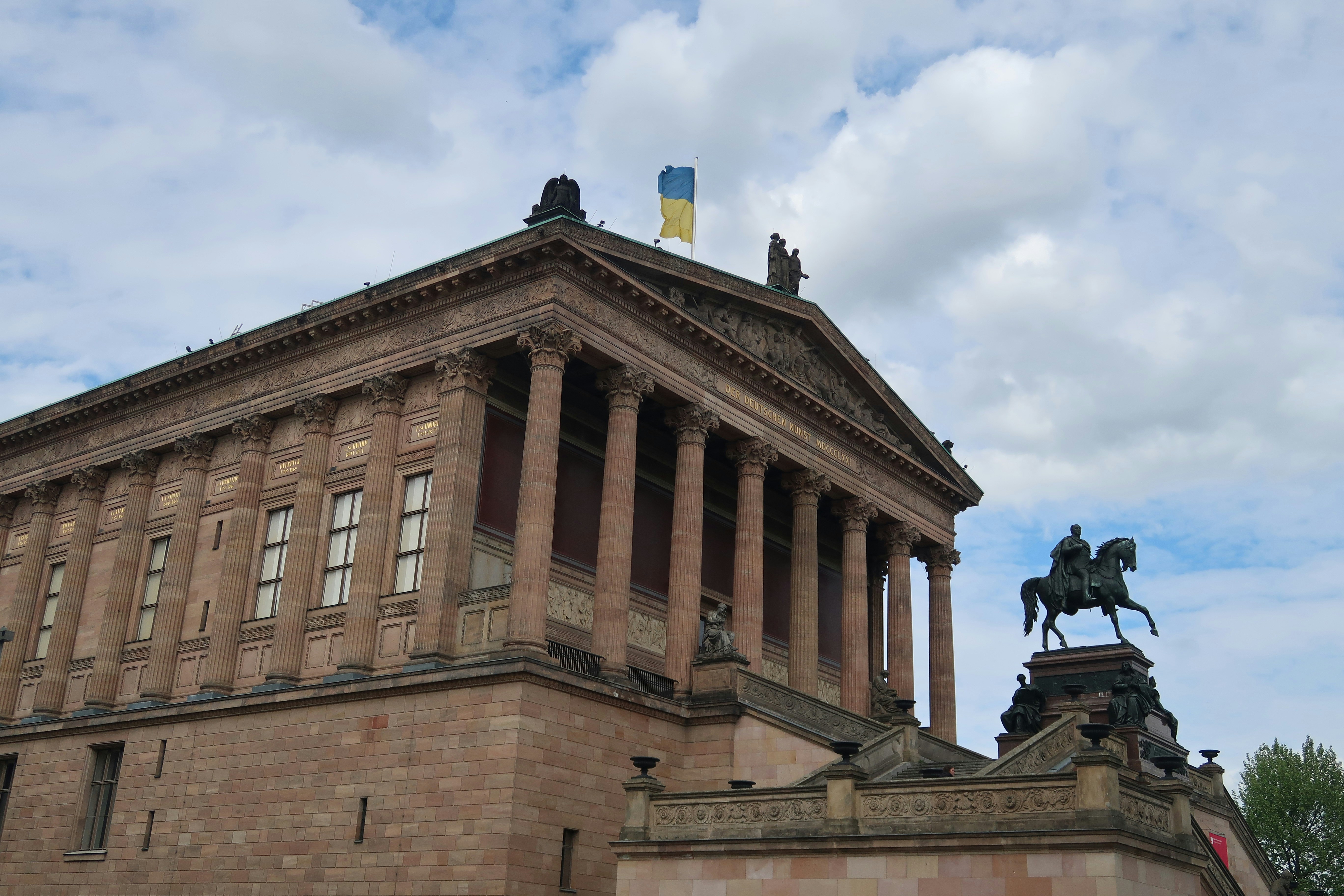 Colossal Pediment and Mounted Statue: A Civic Monument Under a Sky of Parted Clouds
