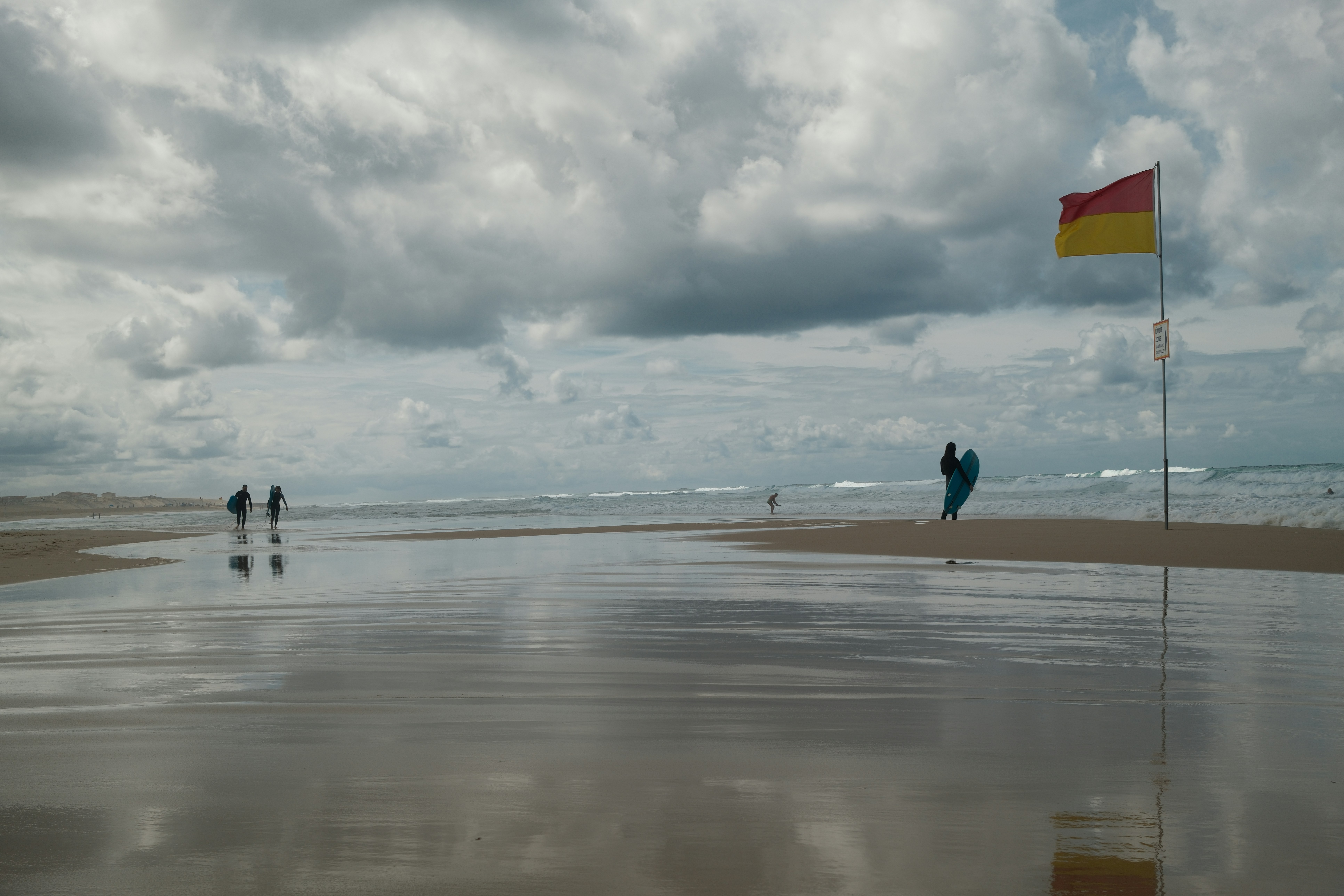 Flag, Shoreline, and Horizon: A Quiet Beach Vigil