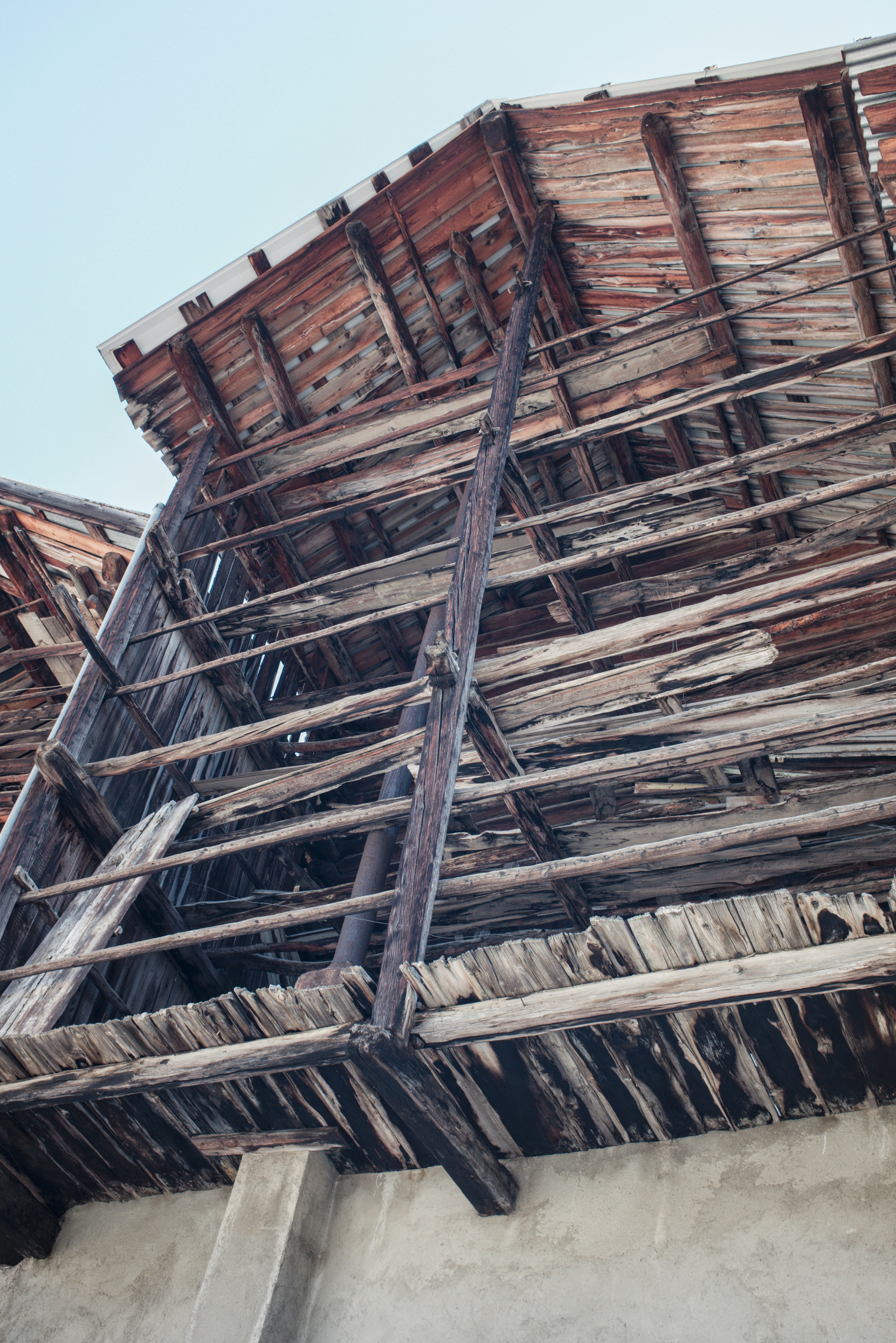 Weathered Timber: An Upward Gaze at a Deteriorating Balcony Structure