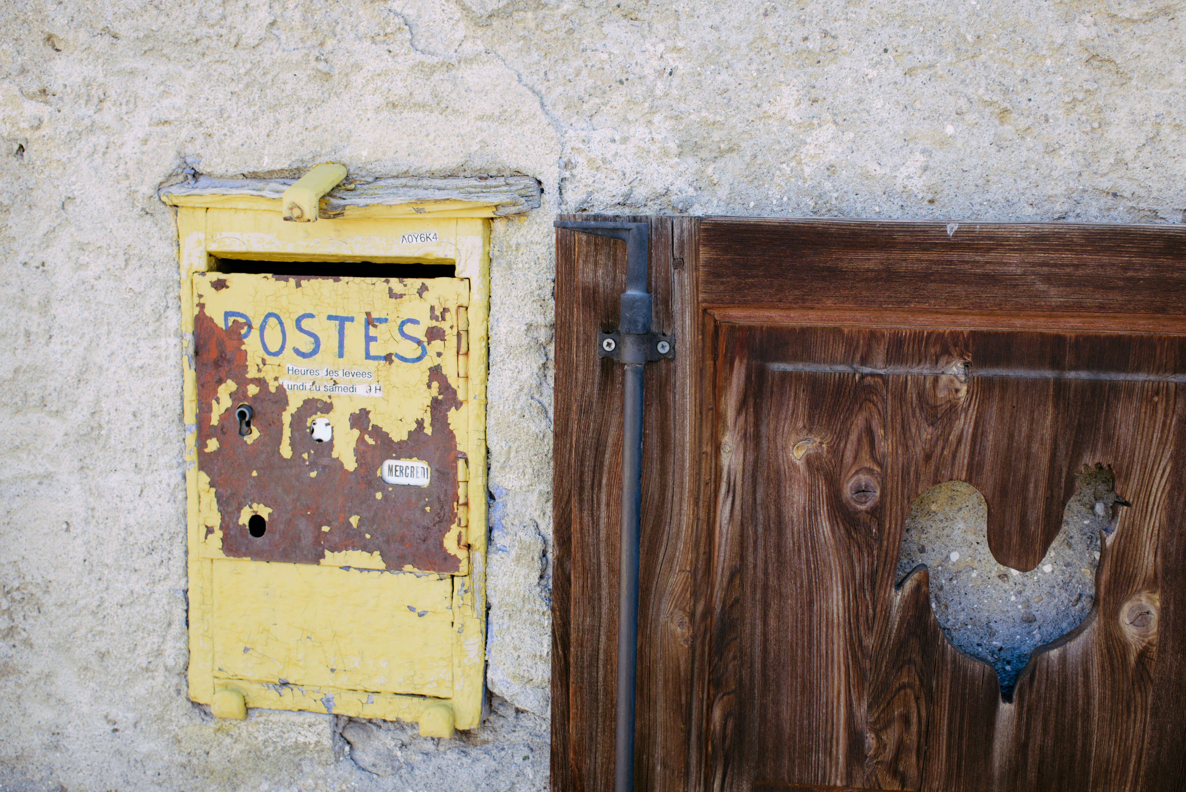 Weathered Yellow Mailbox Adjoins a Timeworn Wooden Door